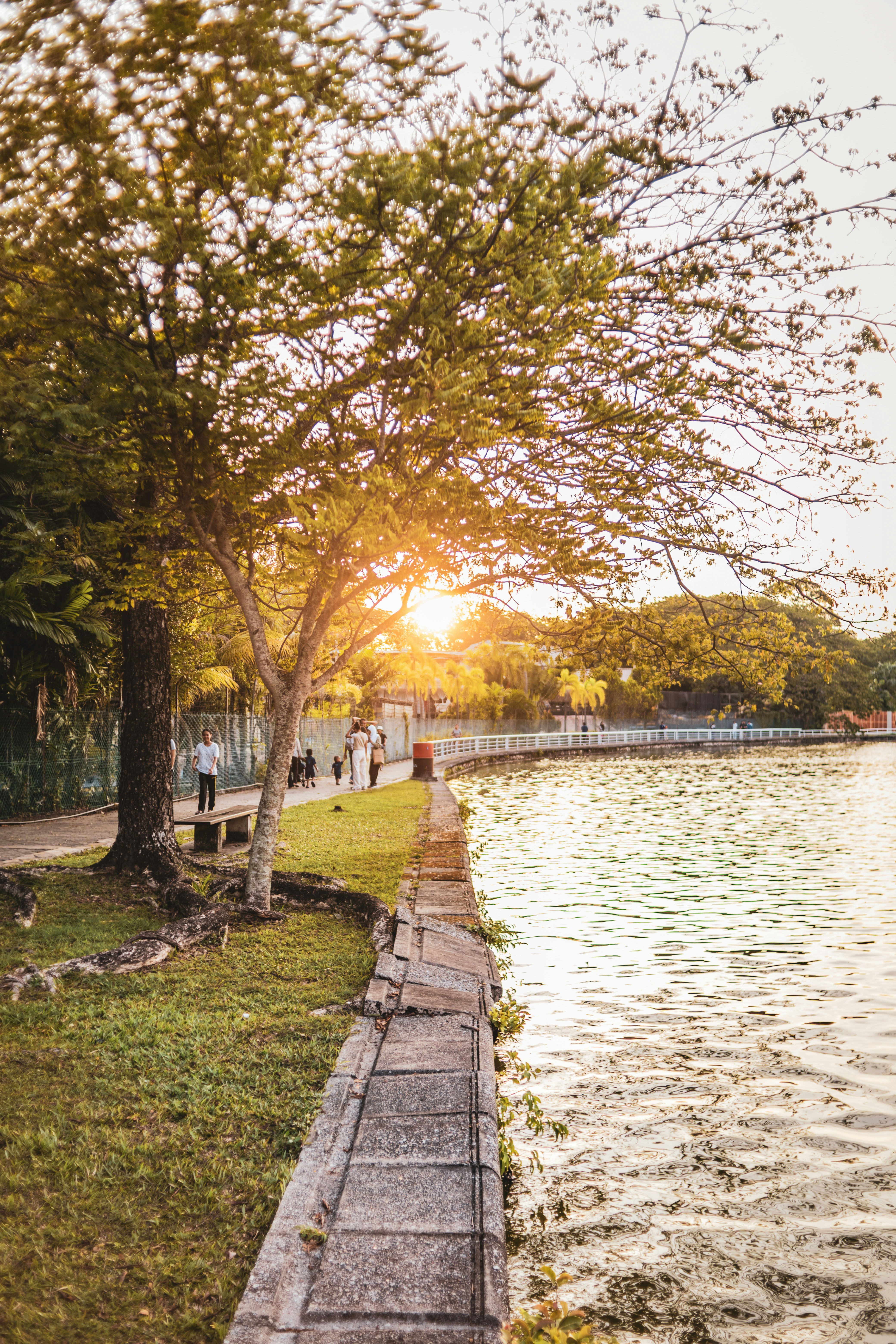 Sunset over a calm lake with people walking