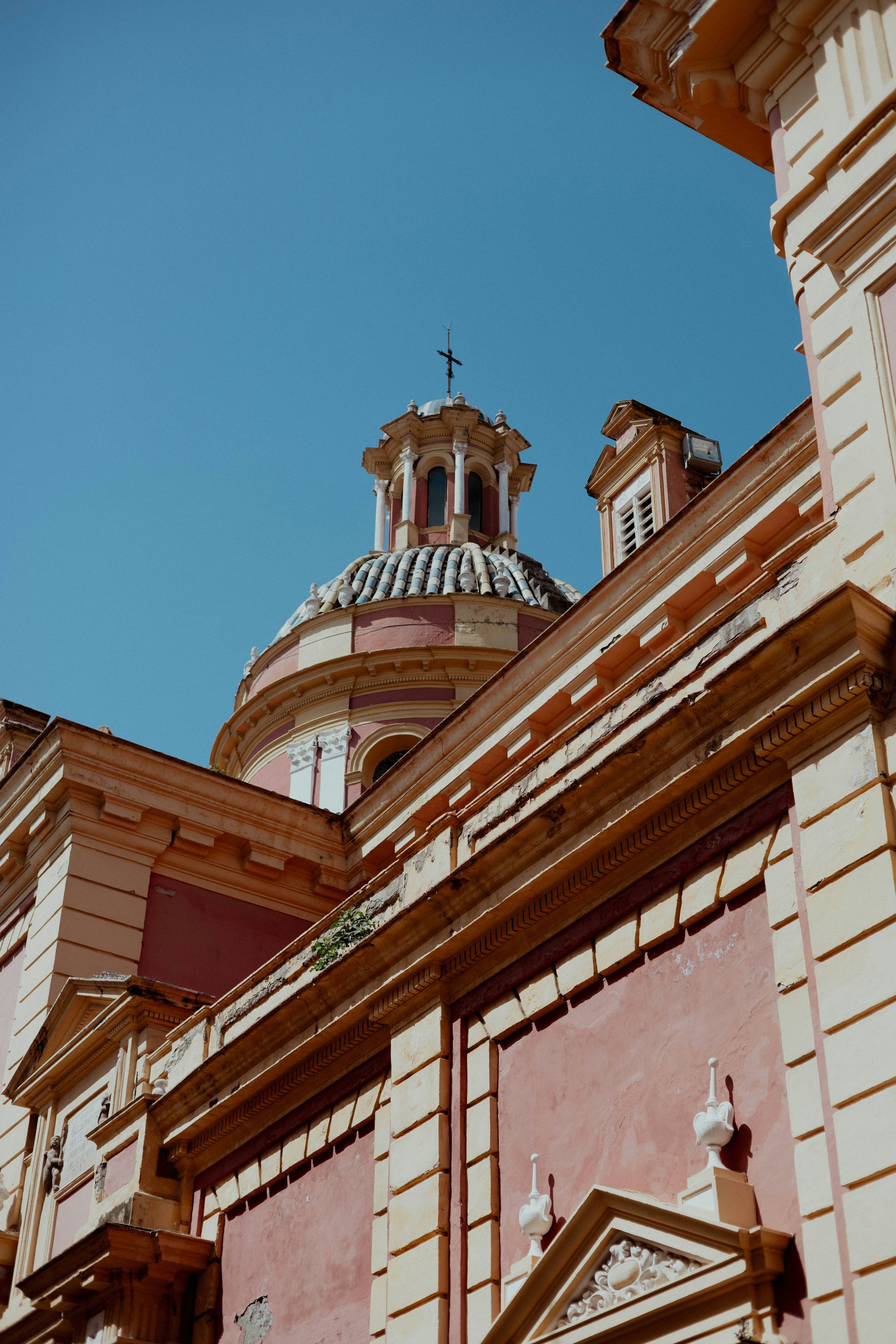 Architectural detail of a historical building featuring a prominent dome and intricate facade in vibrant hues.
