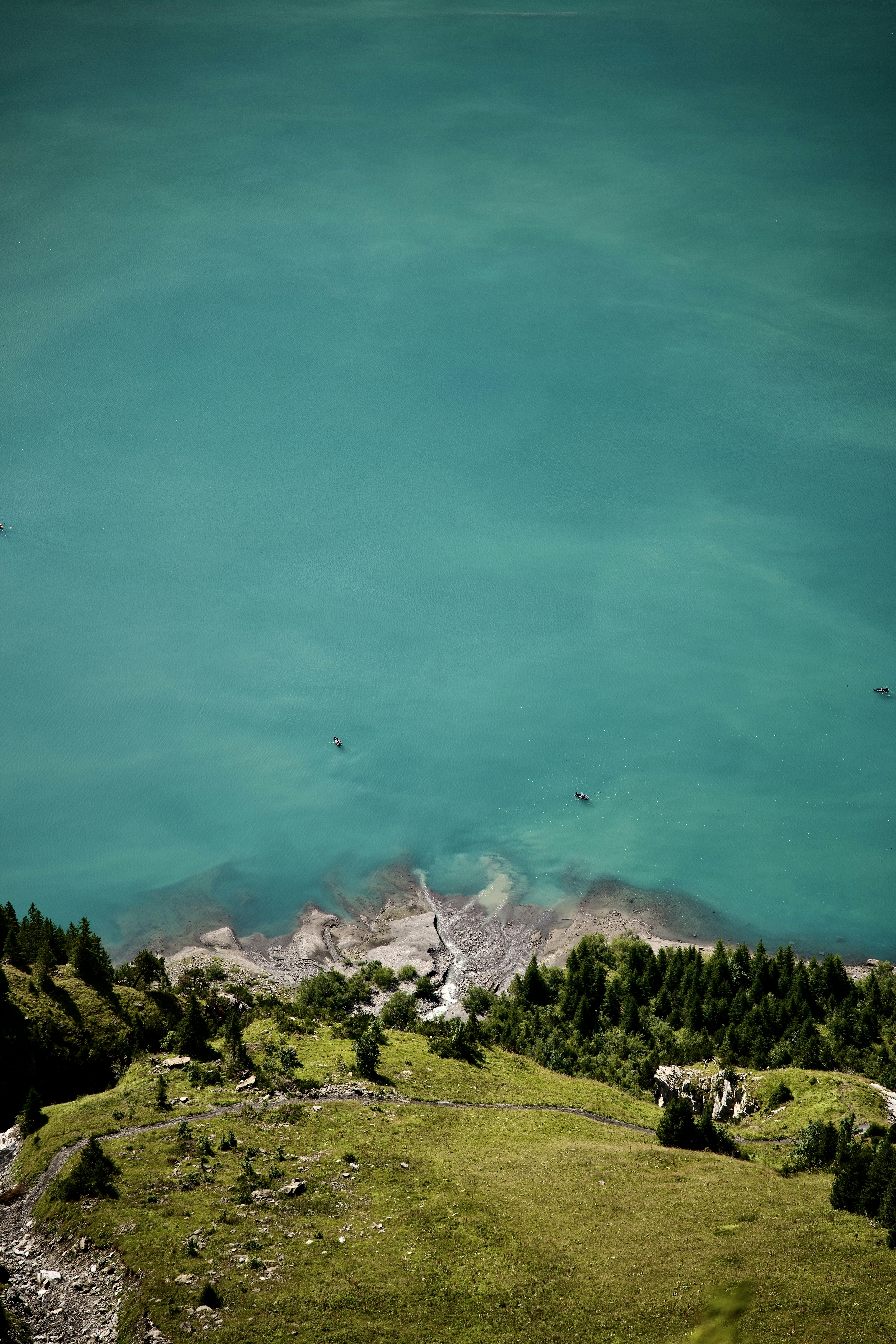 From a hiking trip around Oeschinensee. | Turquoise lake with a green mountainside and trees