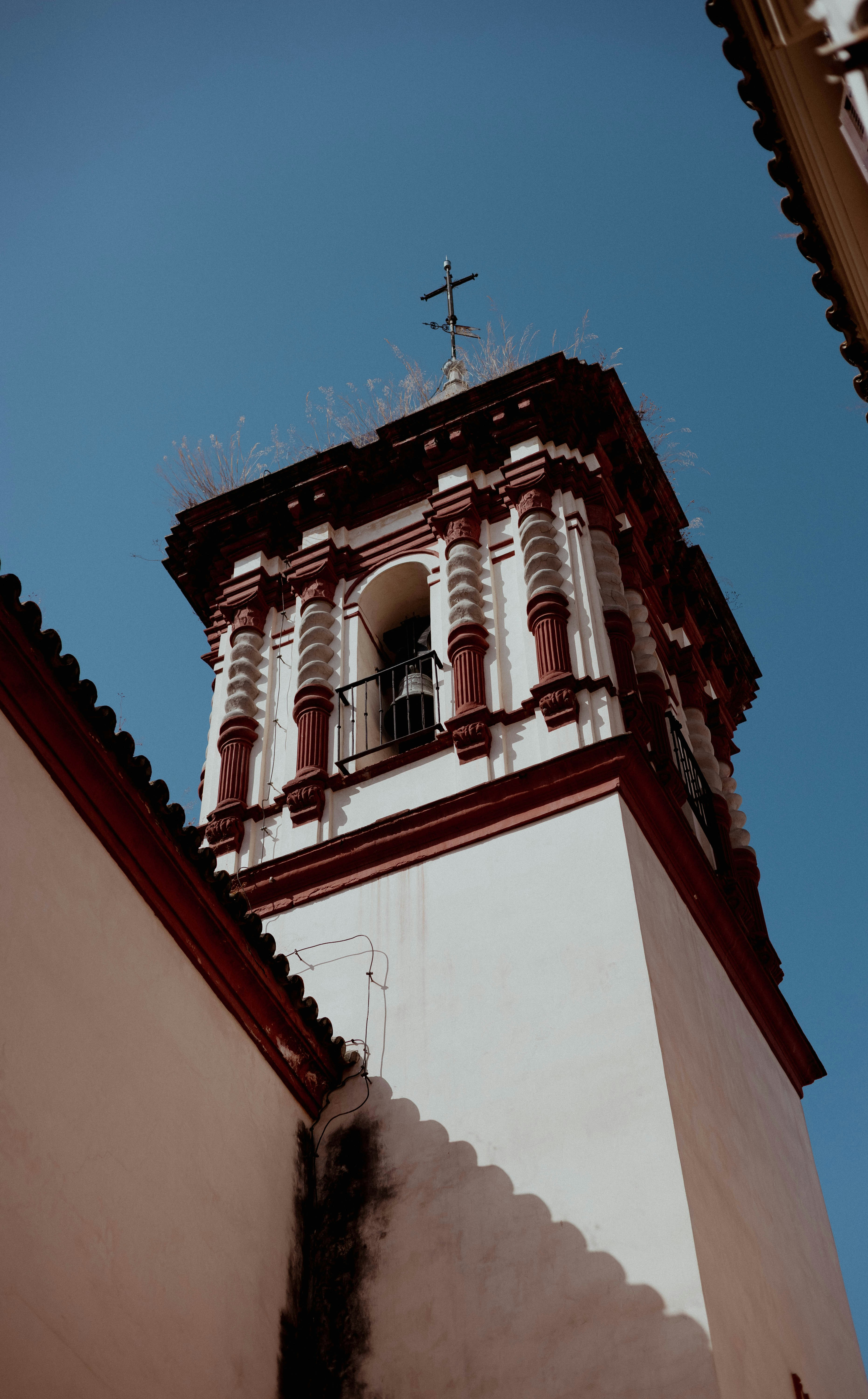 White church tower with red trim against blue sky