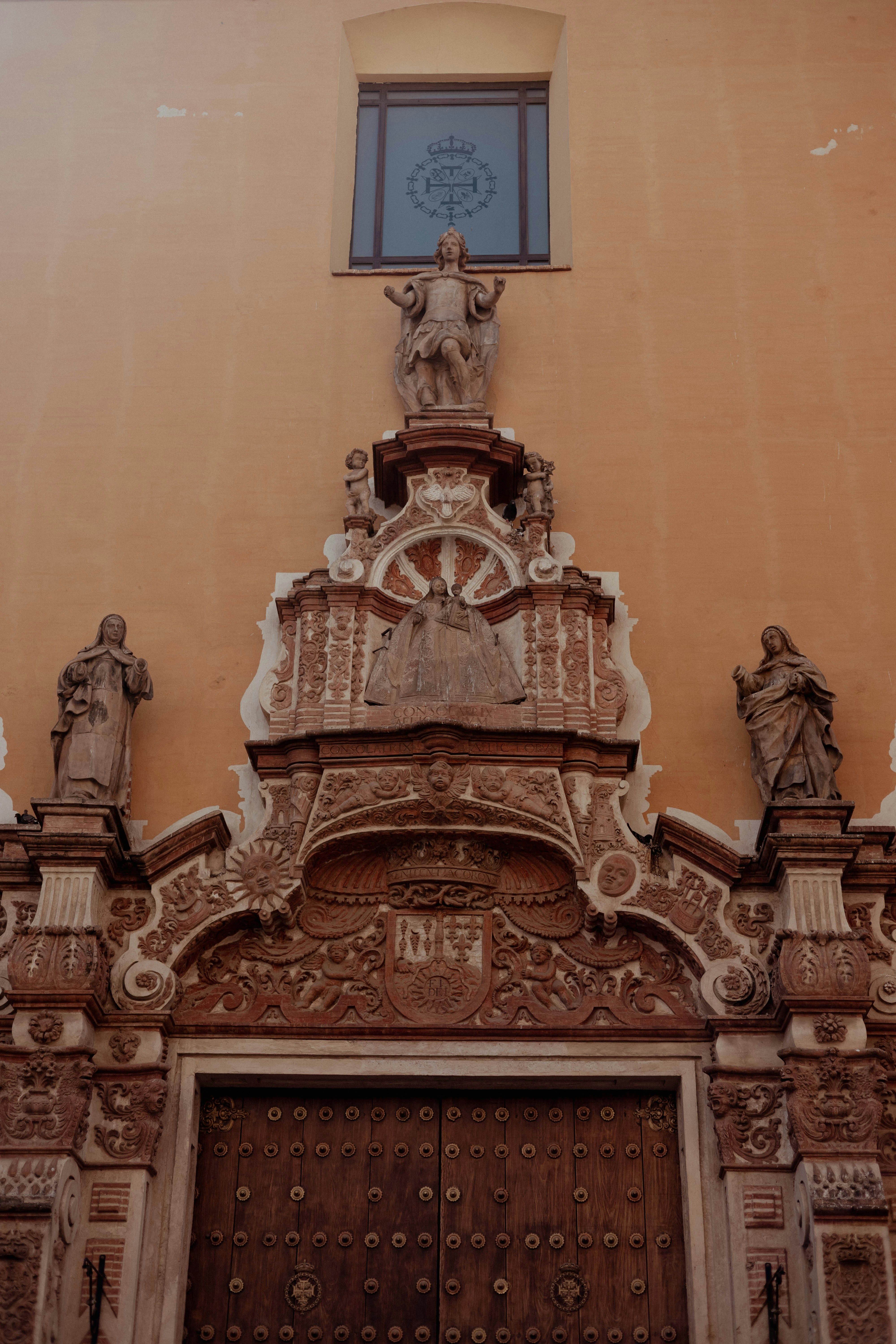 Stone Choir Over a Baroque Portal: The Central Statue Amid Ornate Carvings