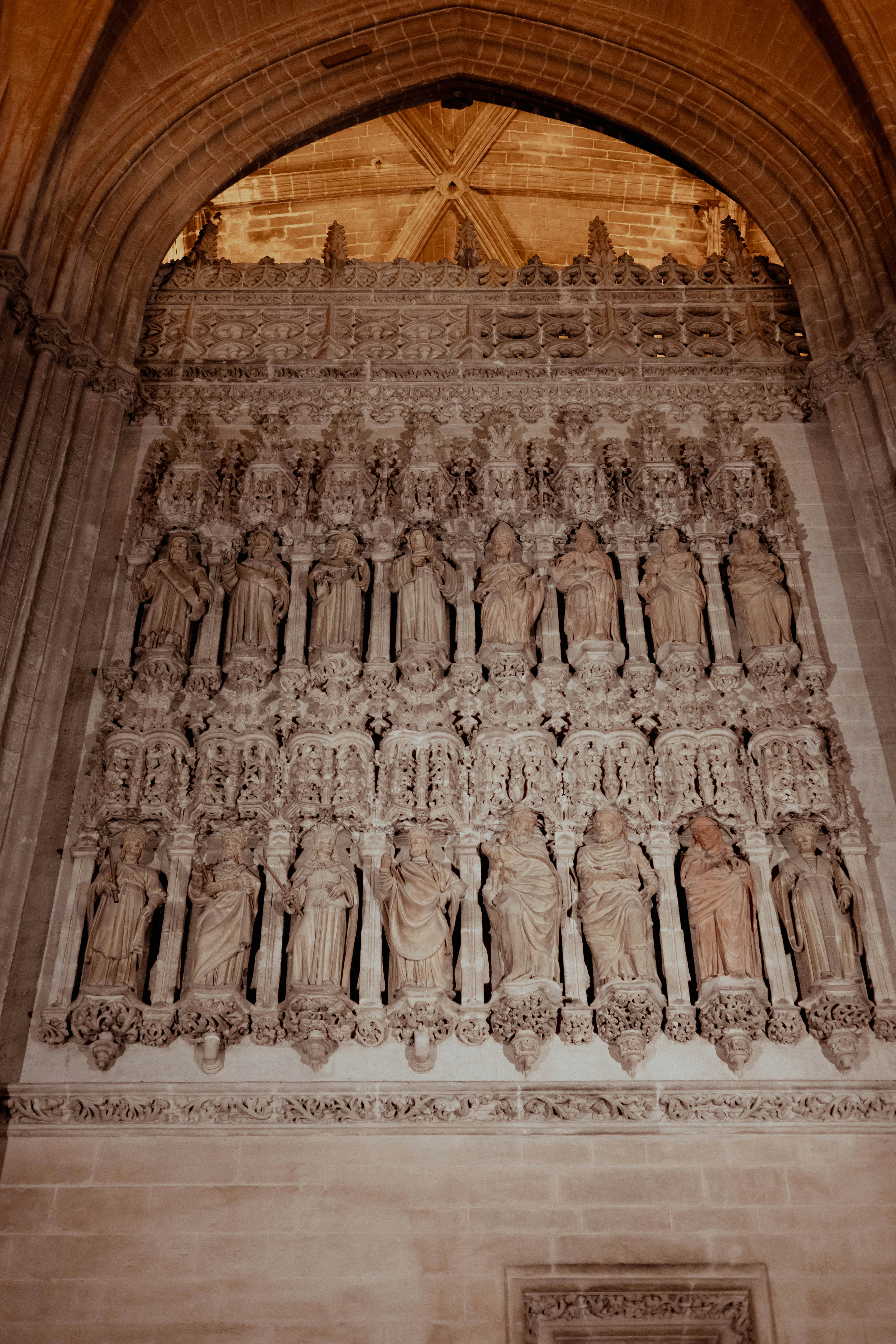 Stone Choir: Saints in a Gothic Relief Under Amber Vault