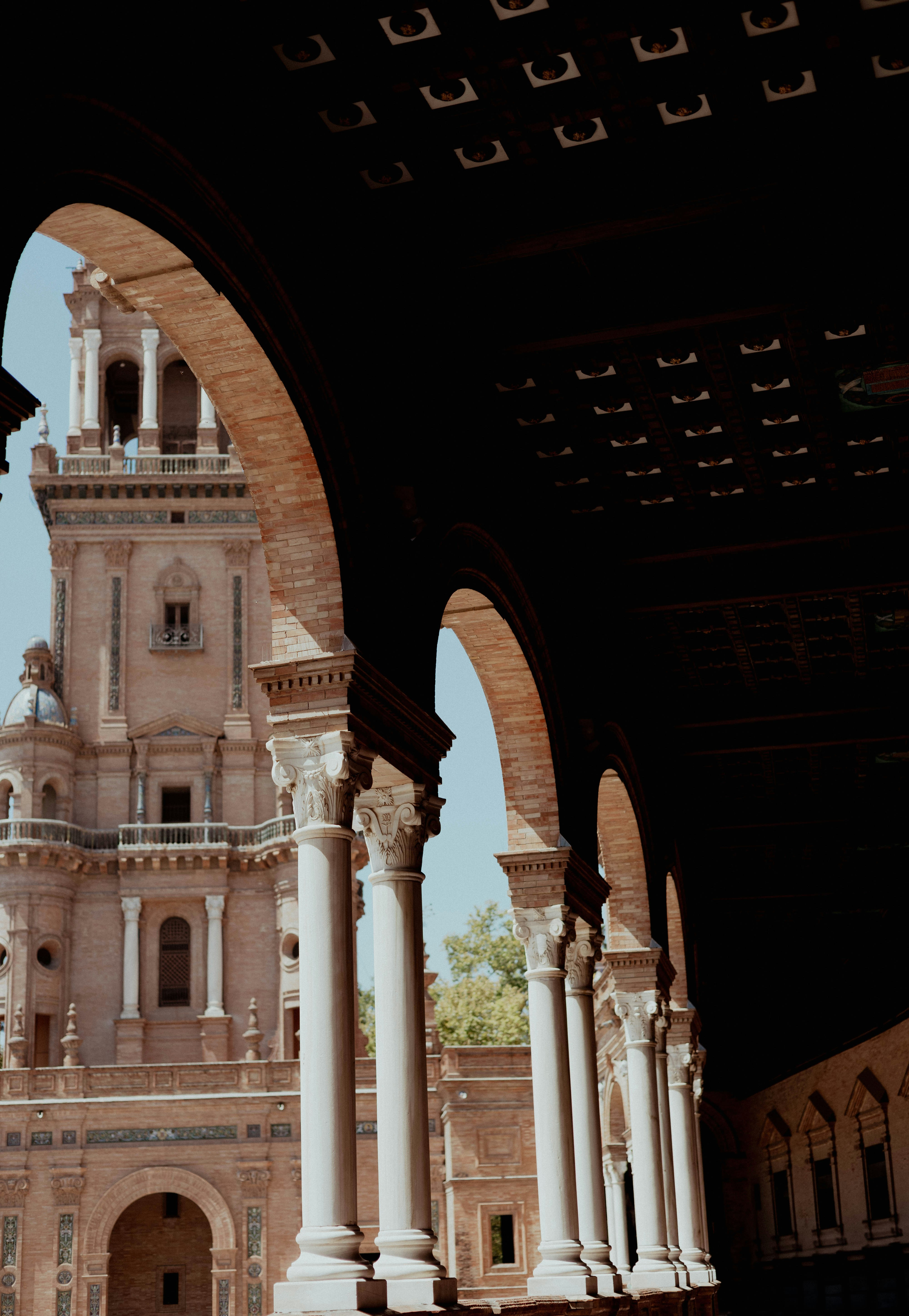 Majestic brick tower framed by elegant arches, showcasing intricate architectural details and a serene sky backdrop.