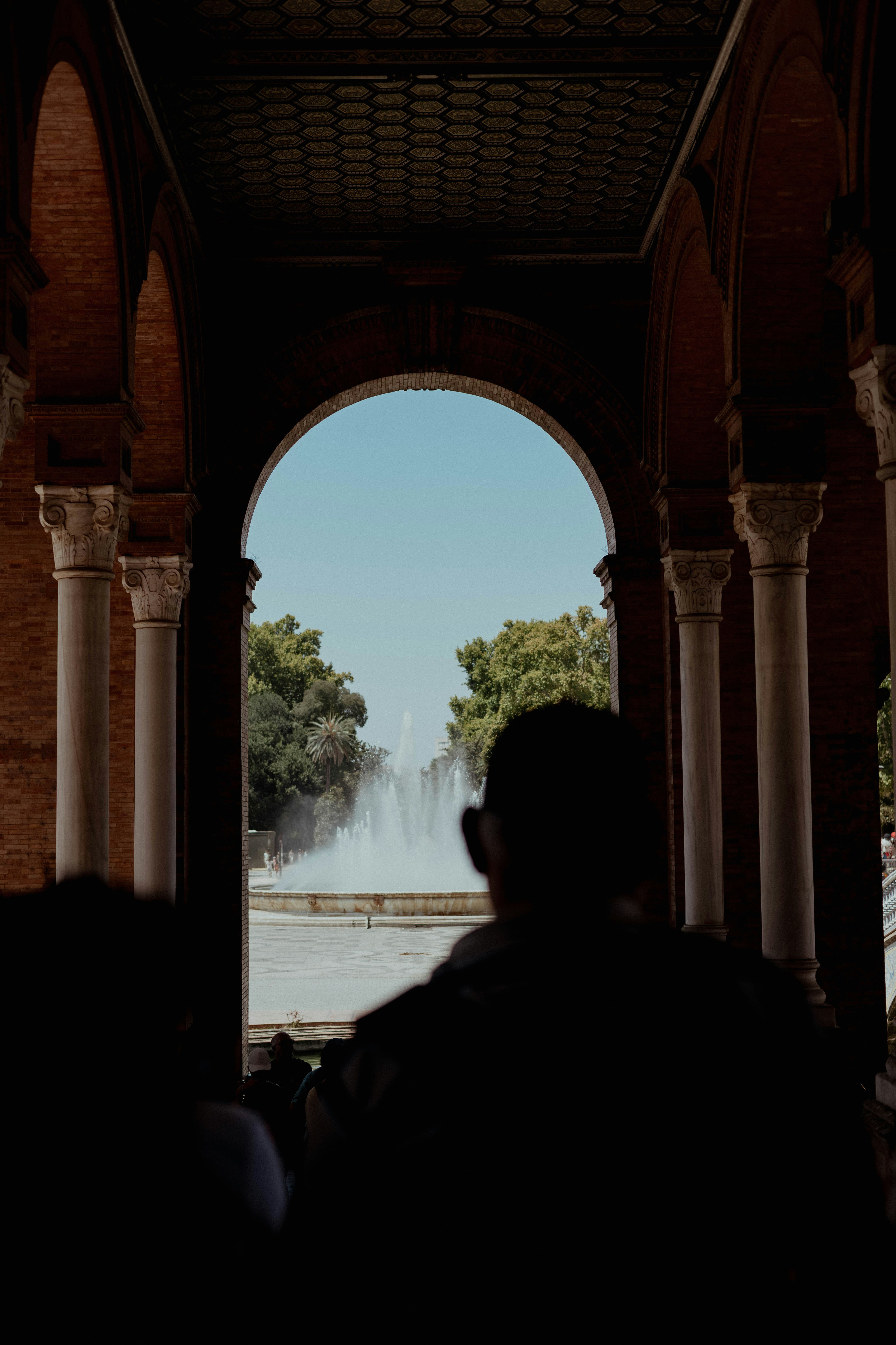 View of a fountain through an arched walkway