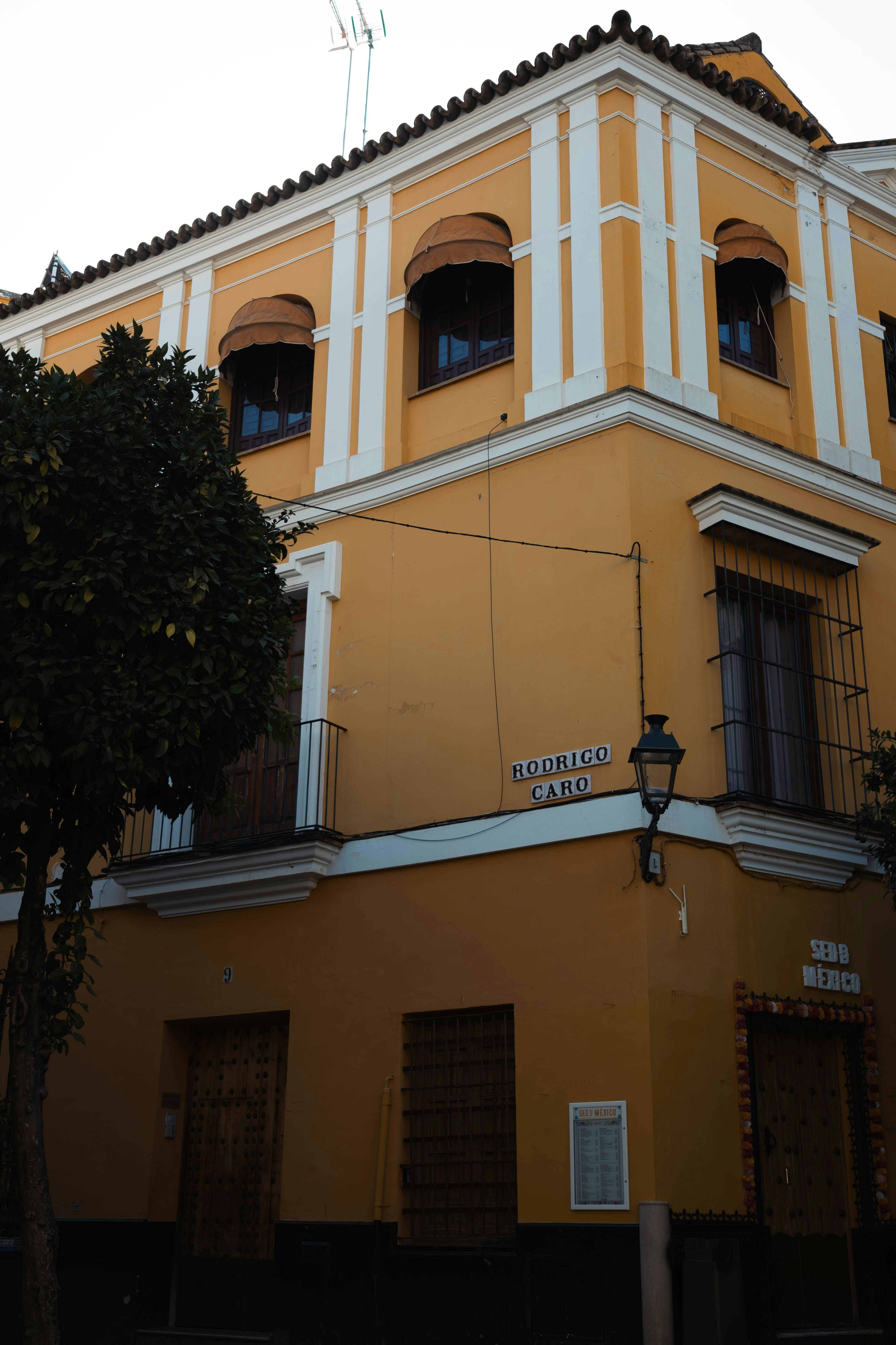 Yellow building corner with windows and awnings