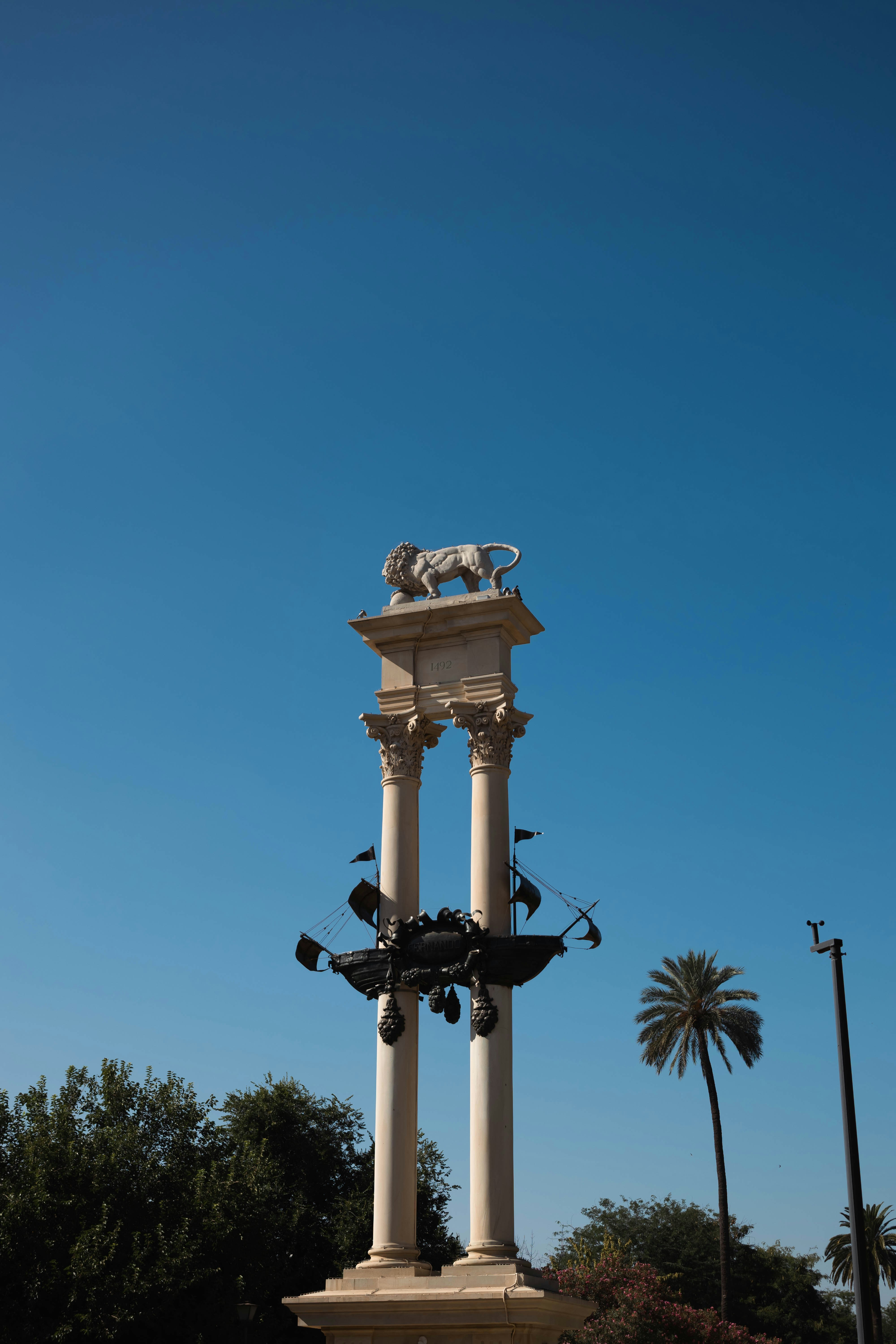 Monument with lion and ships under clear blue sky