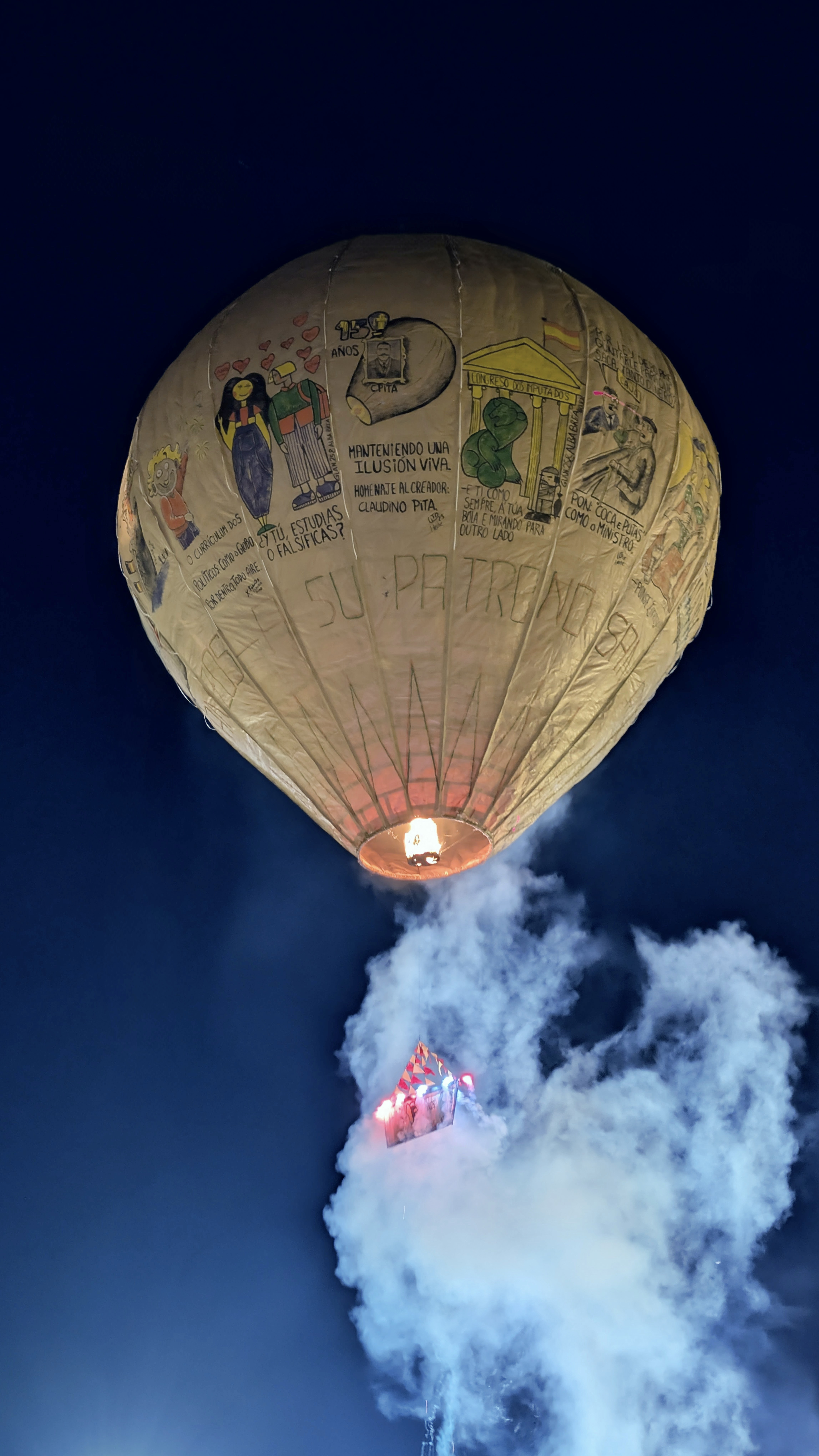 The famous “Globo de Betanzos” rises into the night sky during the San Roque festivity in Galicia, Spain. This giant paper balloon, one of the largest in the world, is a symbol of tradition, celebration, and community. | Hot air balloon with drawings ascends into night sky