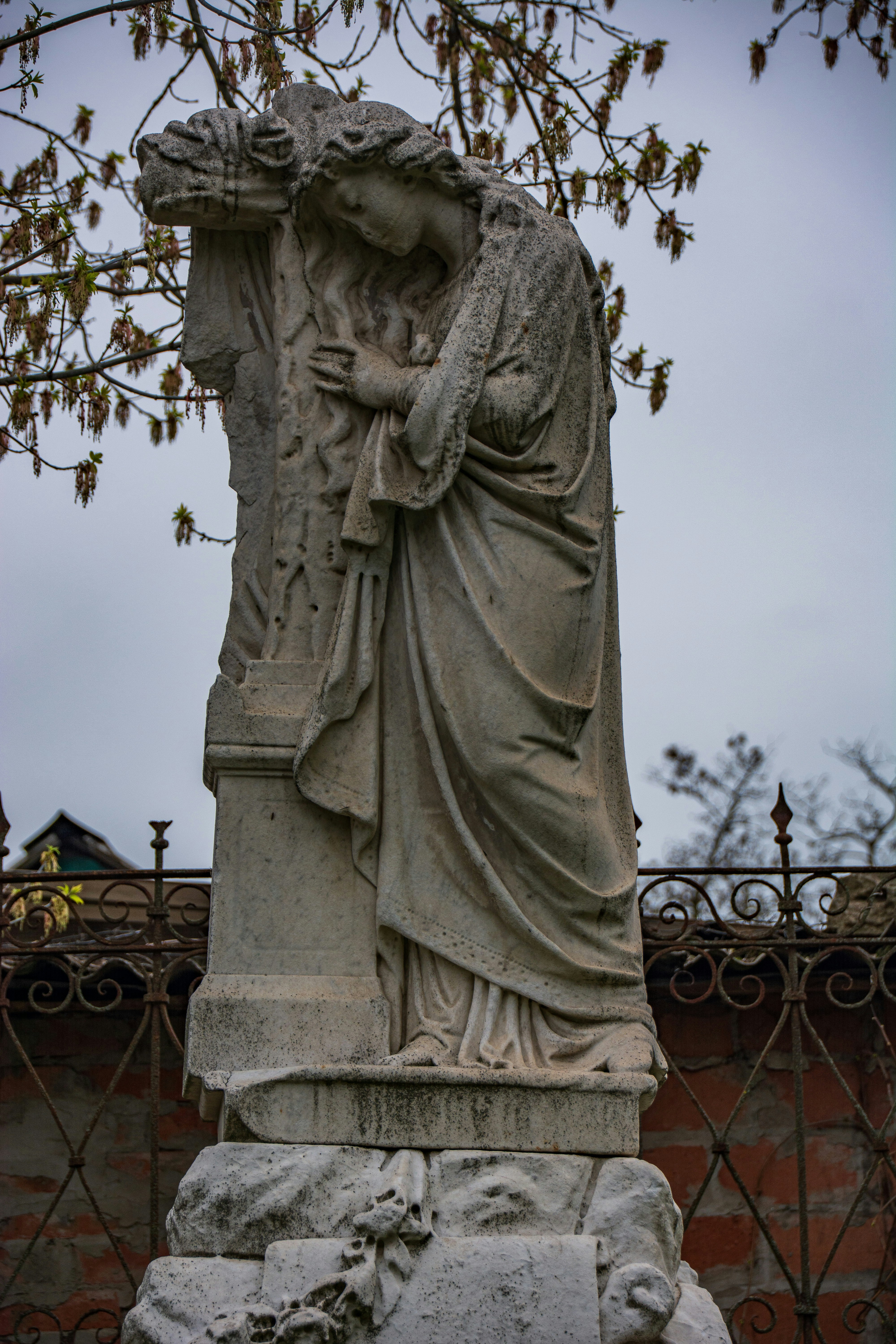 Stone angel sculpture with head bowed at cemetery