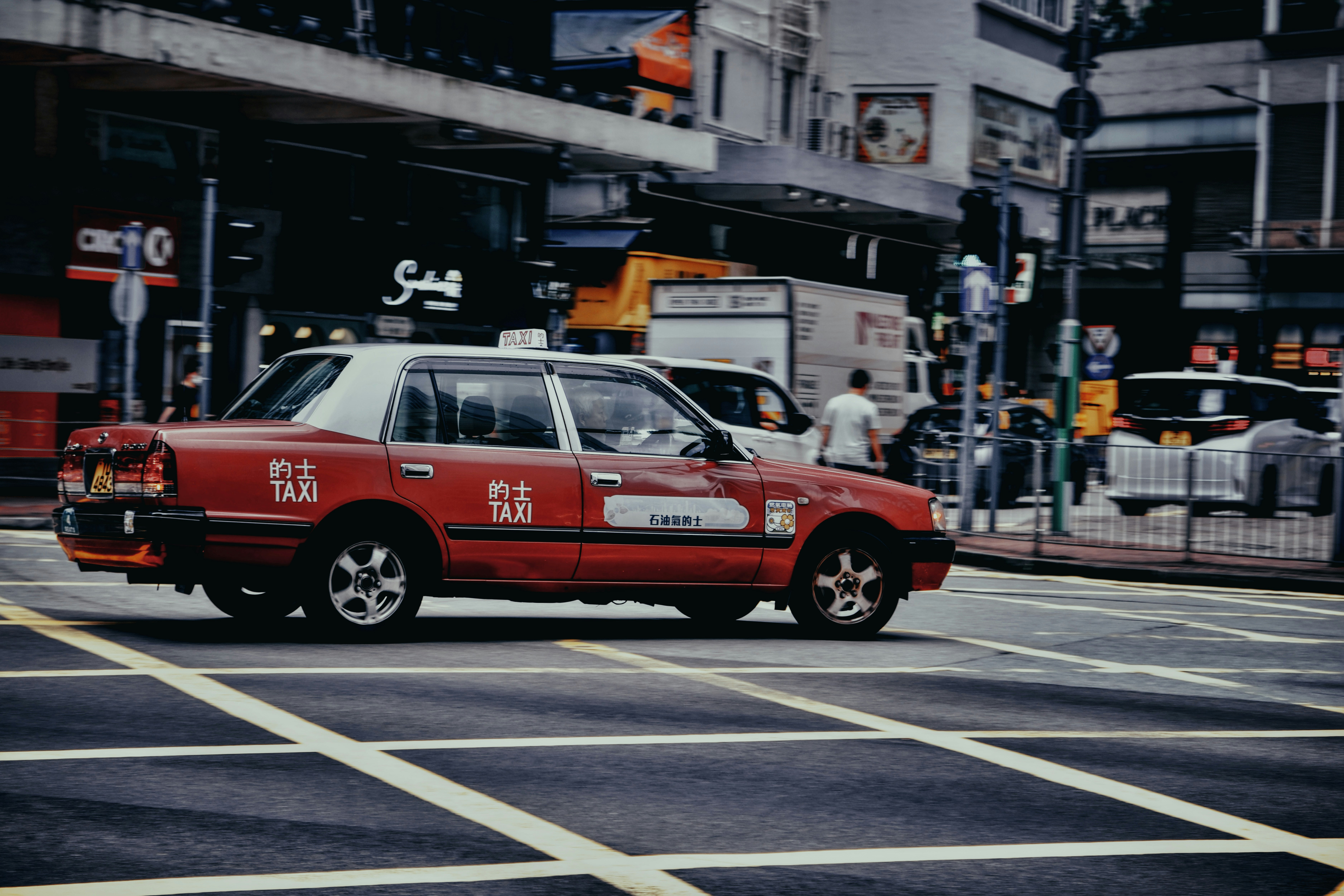 Red taxi driving on a city street