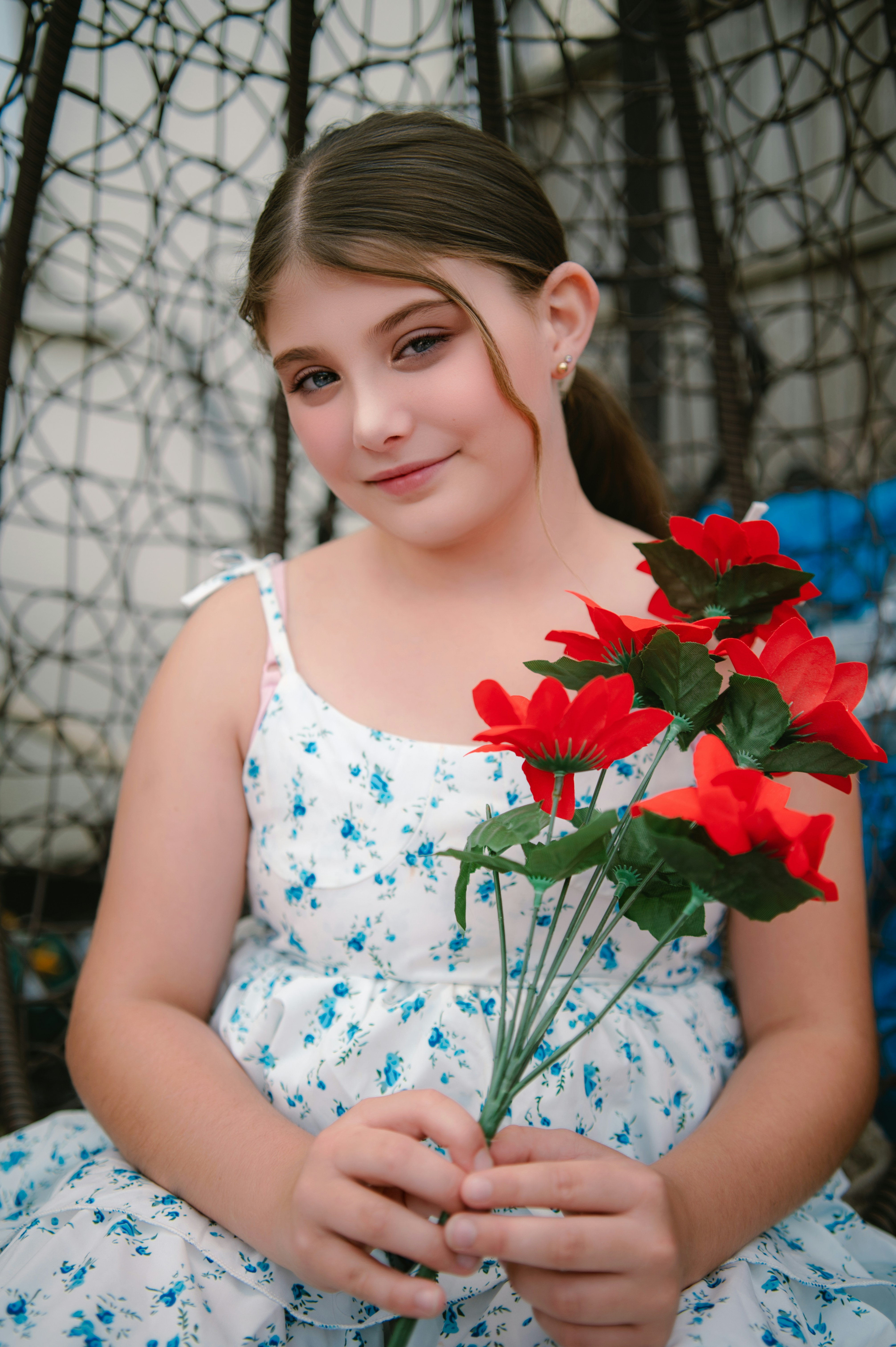 Young girl holding red flowers with white dress