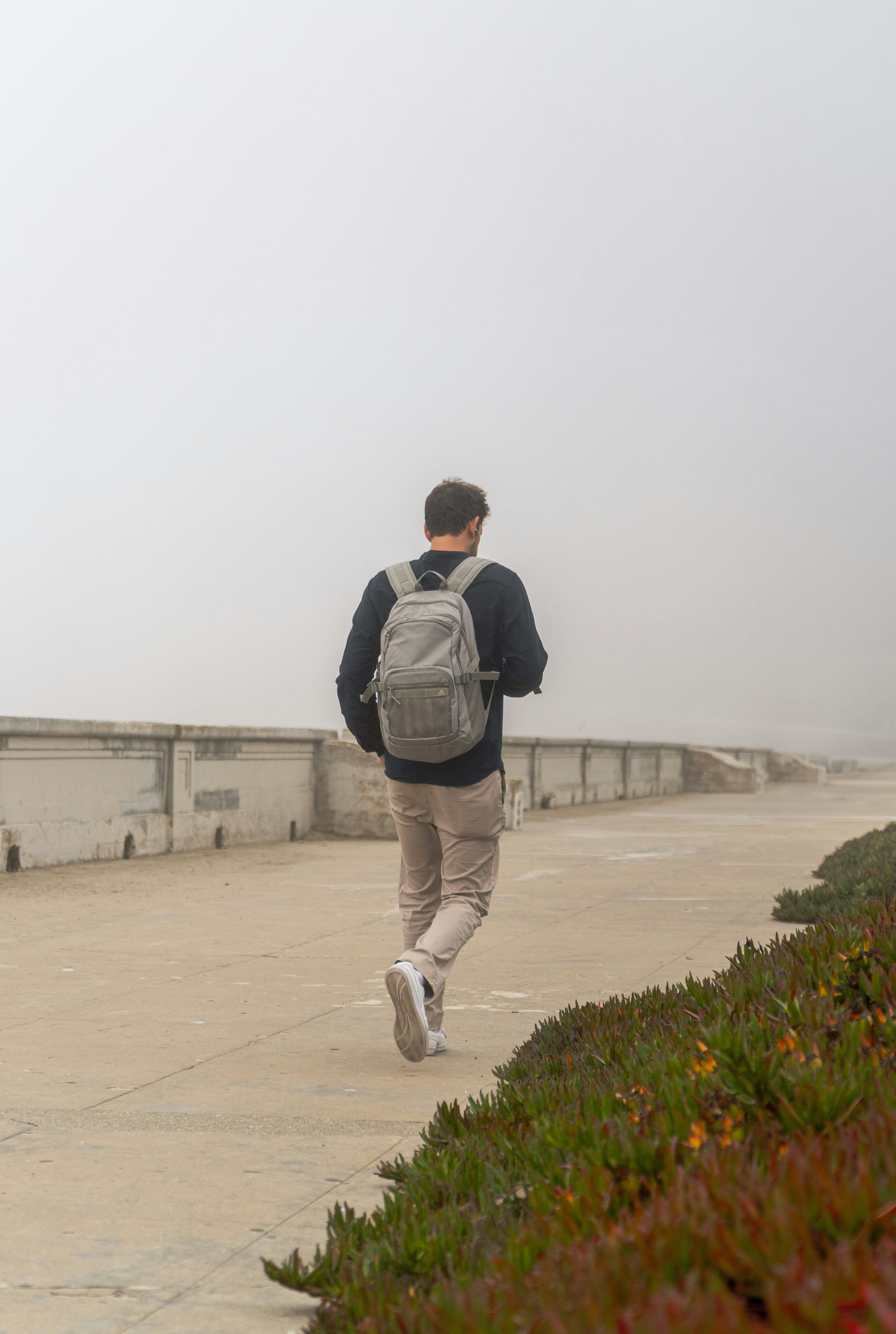 Mist-Washed Departure: A Lone Traveler on a Foggy Pier