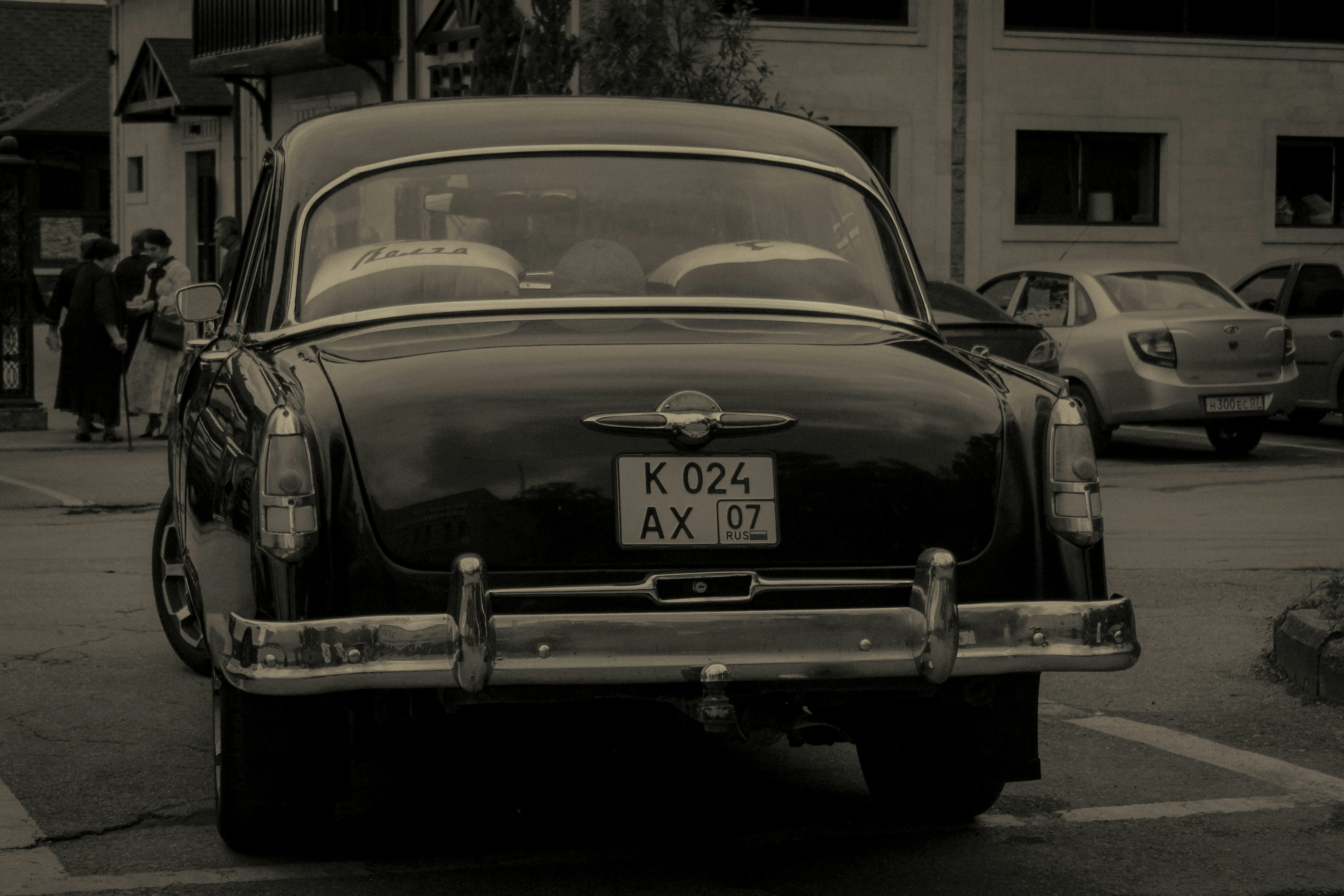 Rear view of a vintage black car parked outside.