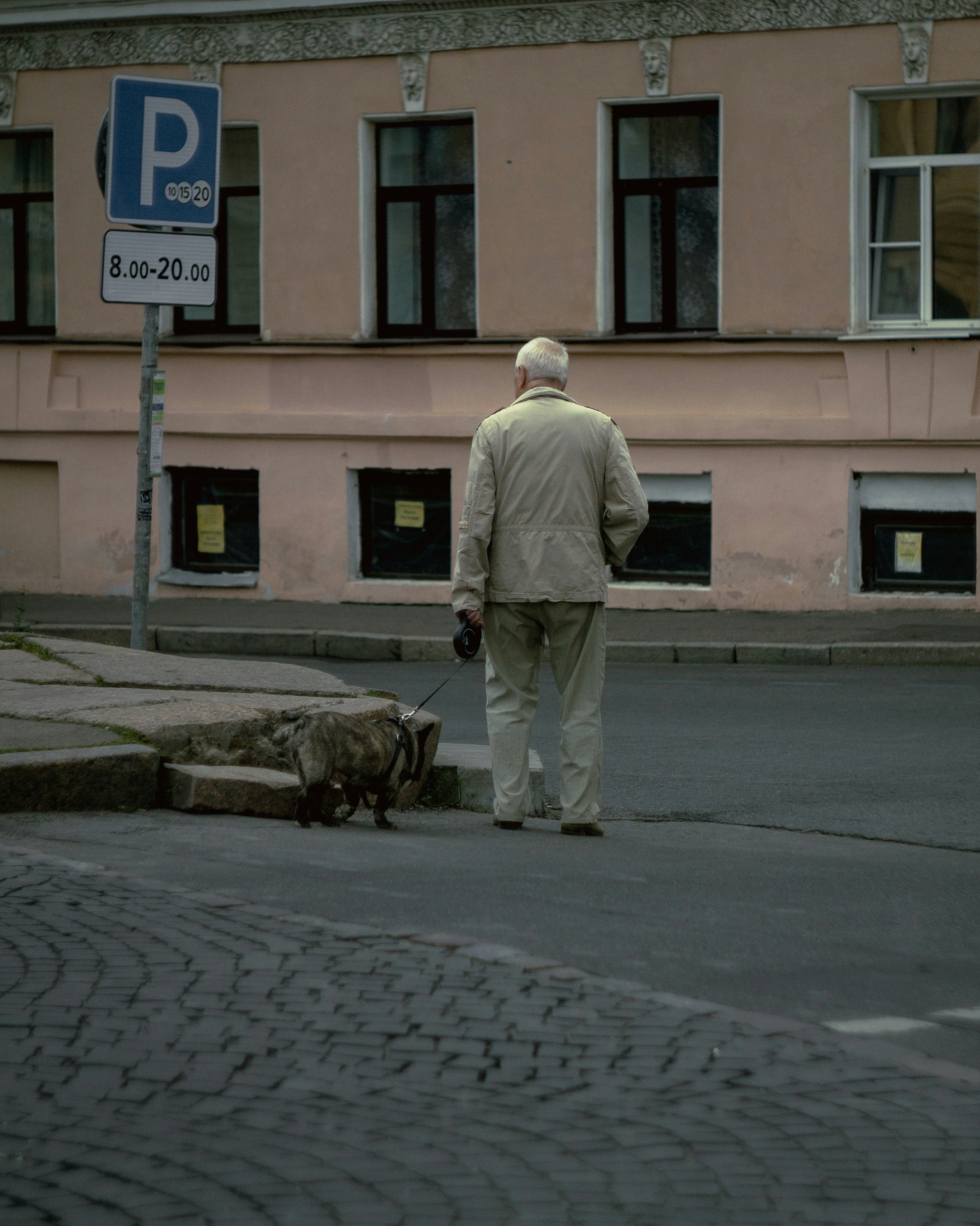 Man walks dog on city street