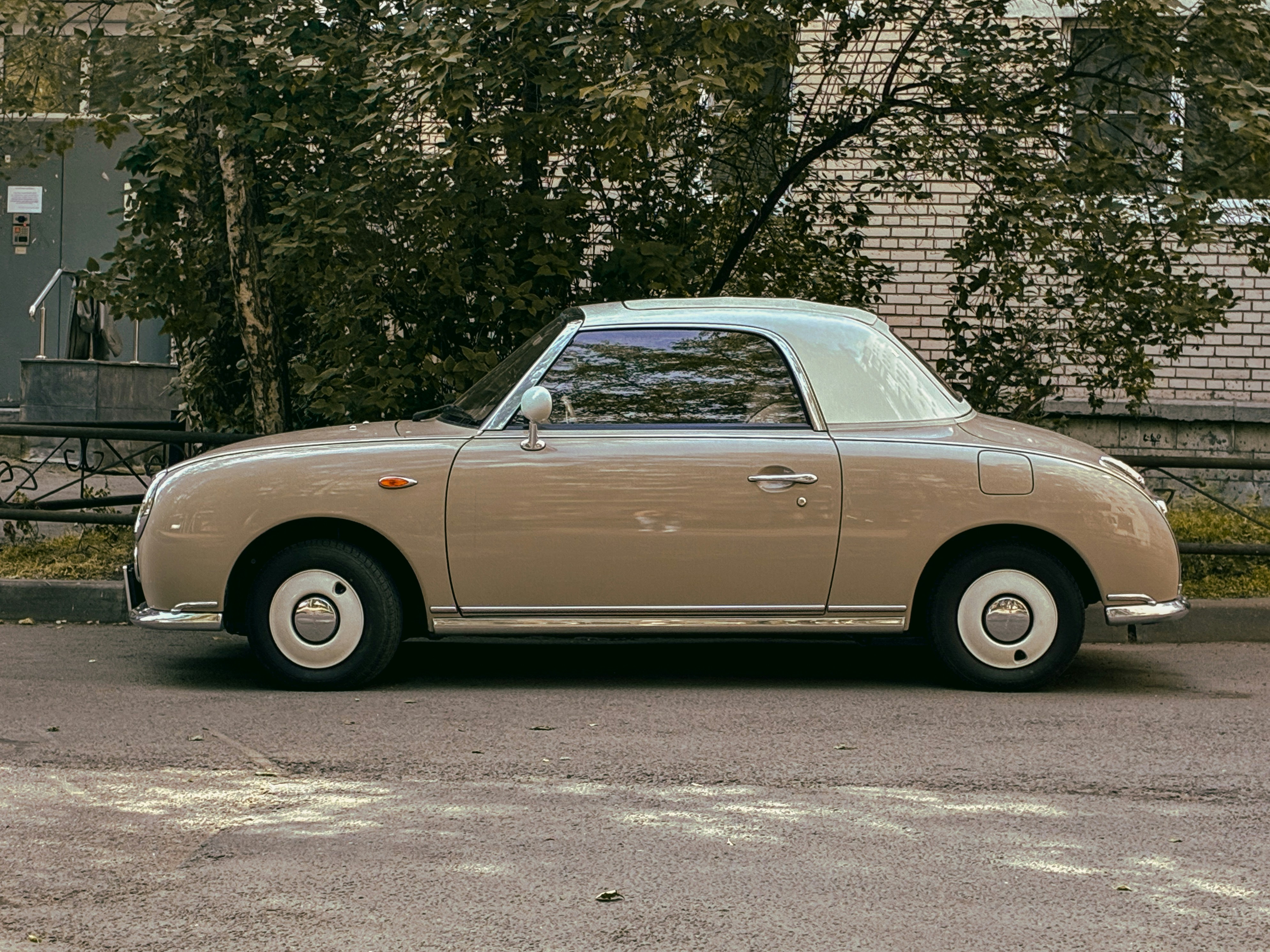 Tan convertible car parked on a street