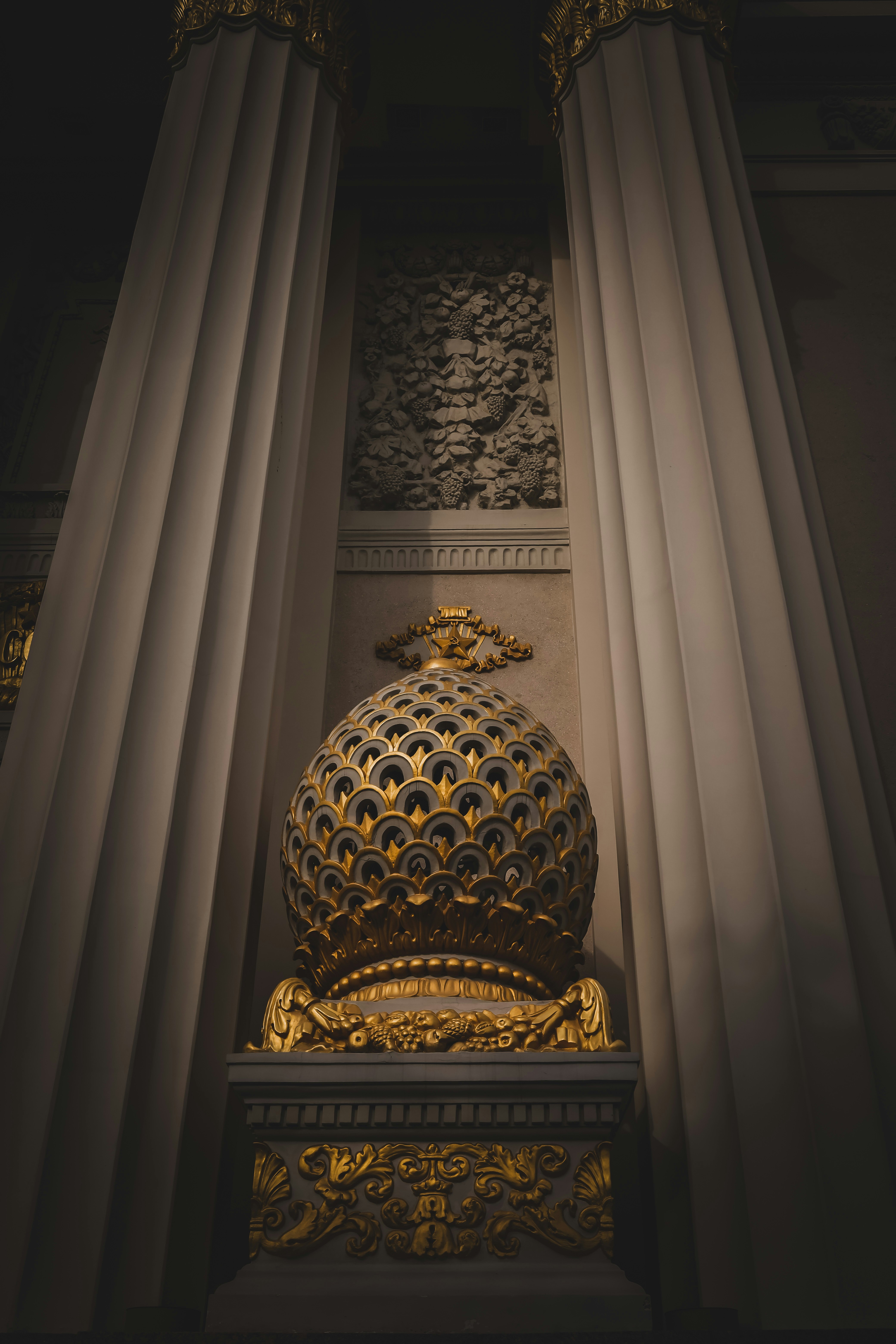 Ornate golden sculpture between two large columns