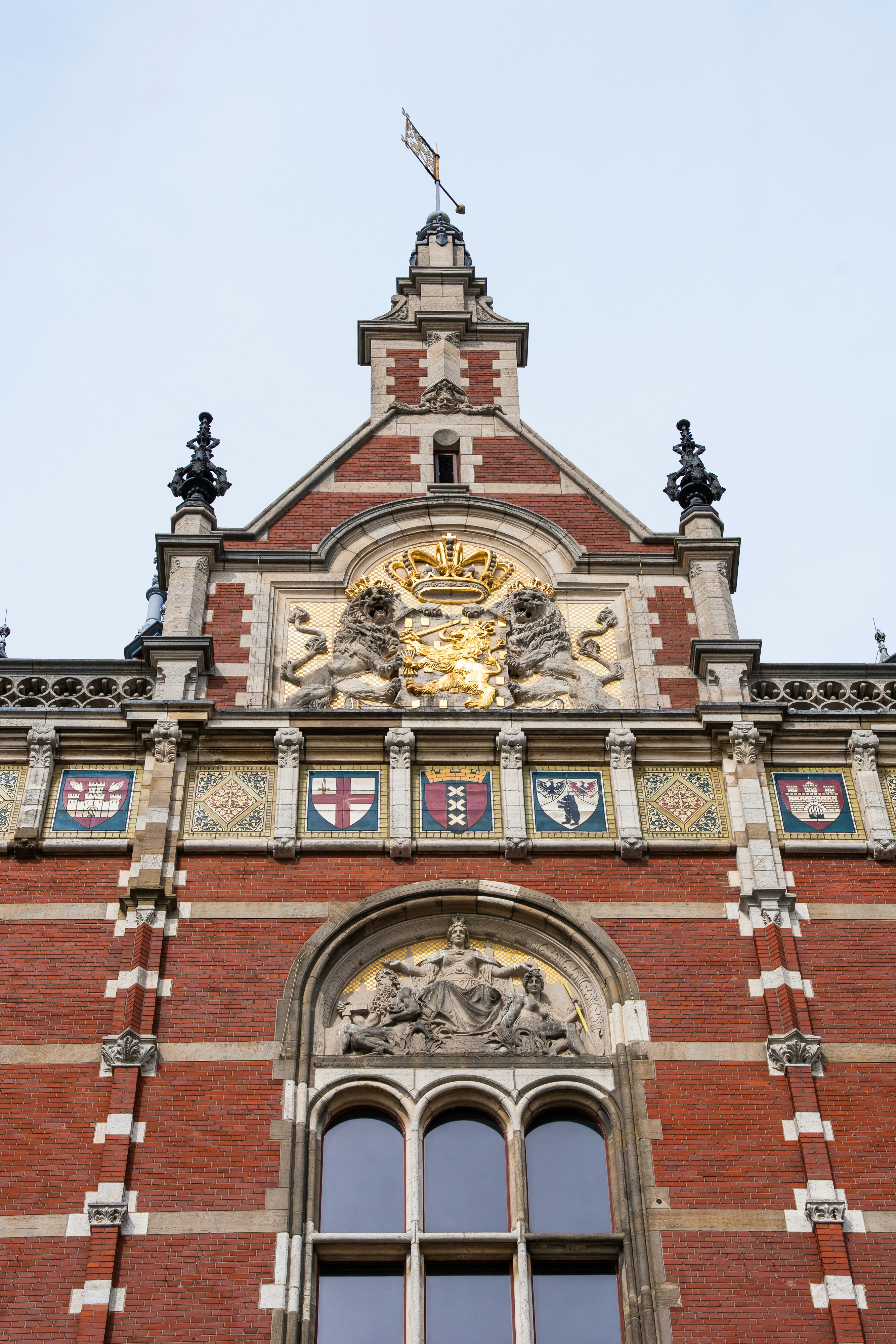 Intricate facade of a historic building adorned with coats of arms and sculptural details, showcasing architectural artistry.