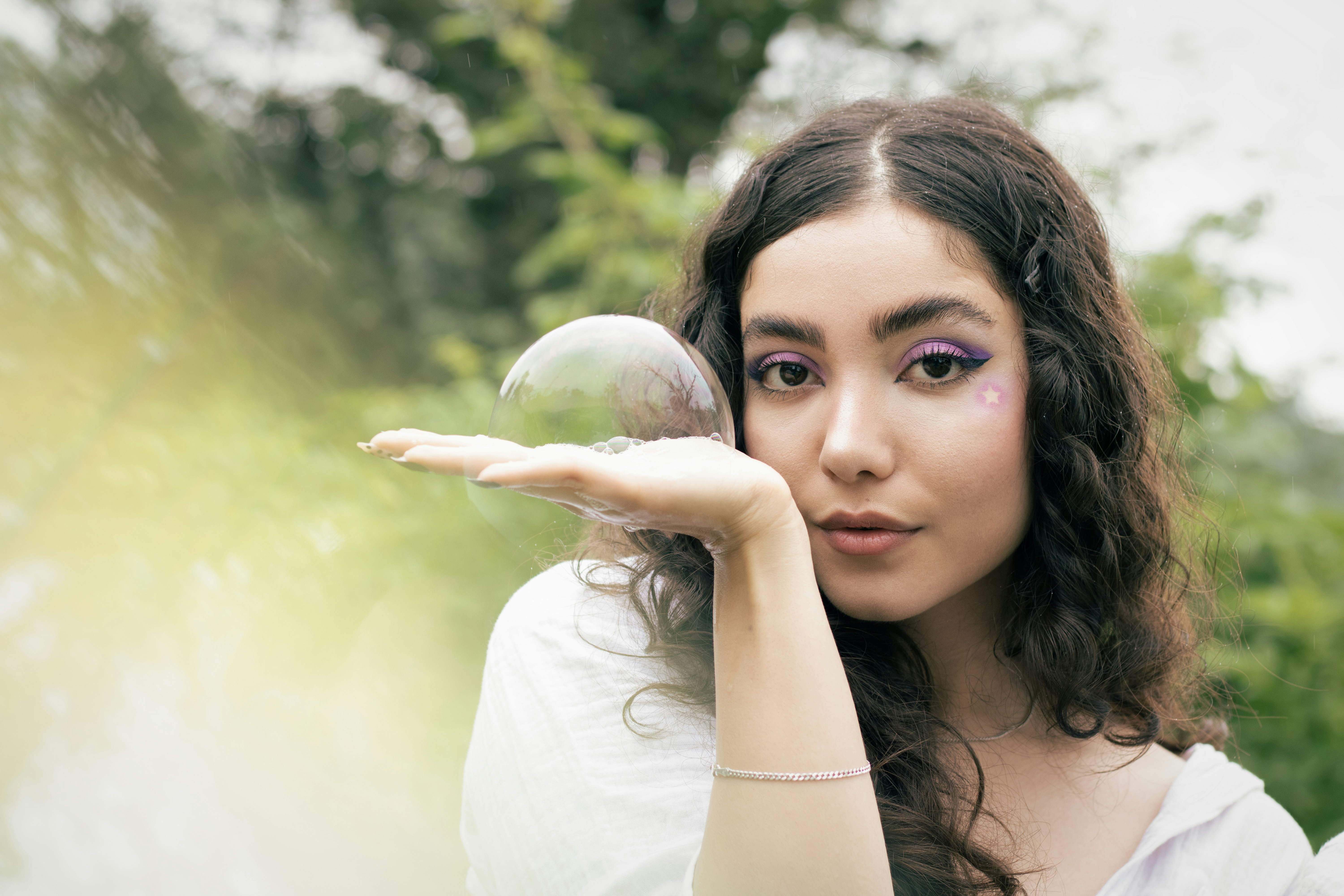 Bubble on the Hand, Quiet Gaze: A Portrait in Soft Focus
