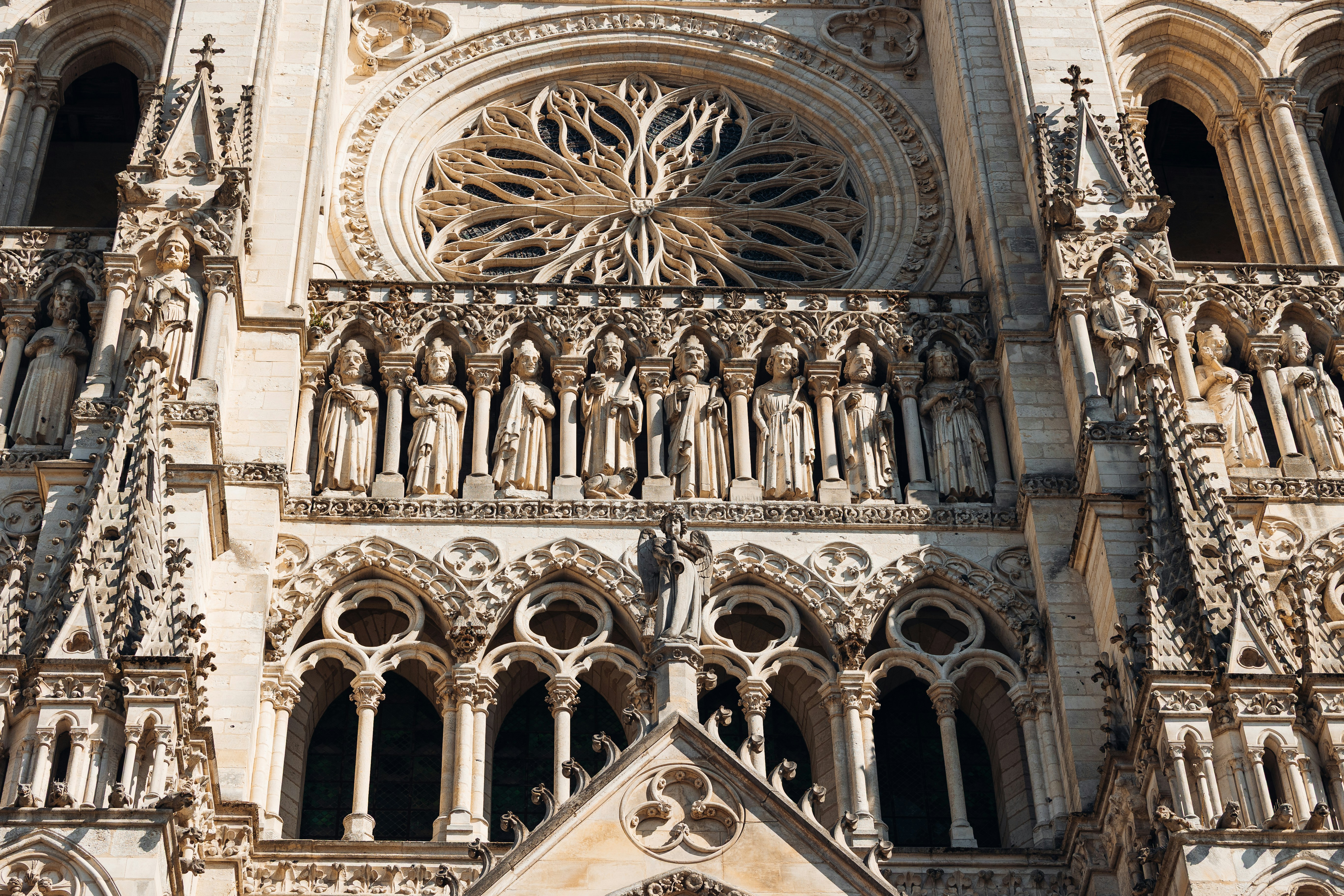 Amiens Cathedral Rose Window and Gallery of Kings – Gothic Facade of Notre Dame d’Amiens | Ornate facade of a gothic cathedral with statues.