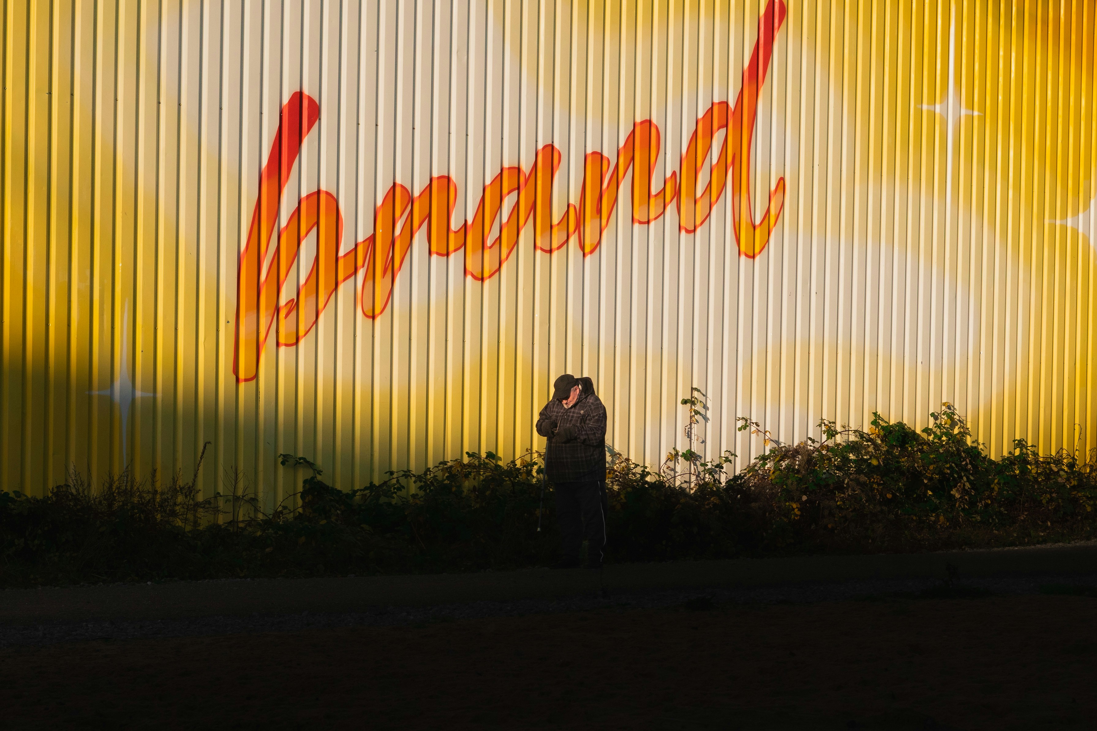 Couple kissing in front of a large yellow wall with "brand" text.