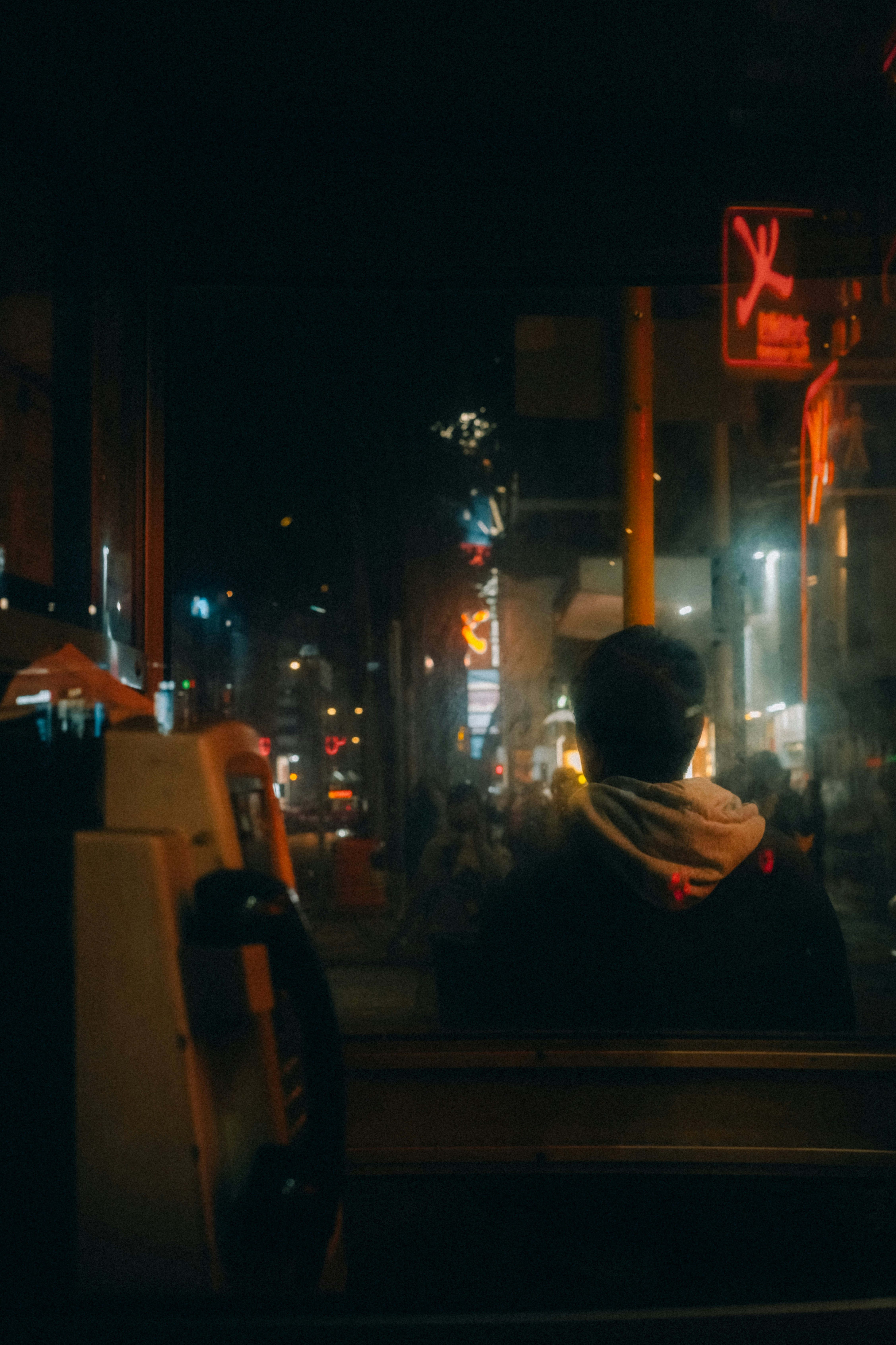 Hong Kong Street View - Sun Hung | Person looking out window at city lights at night