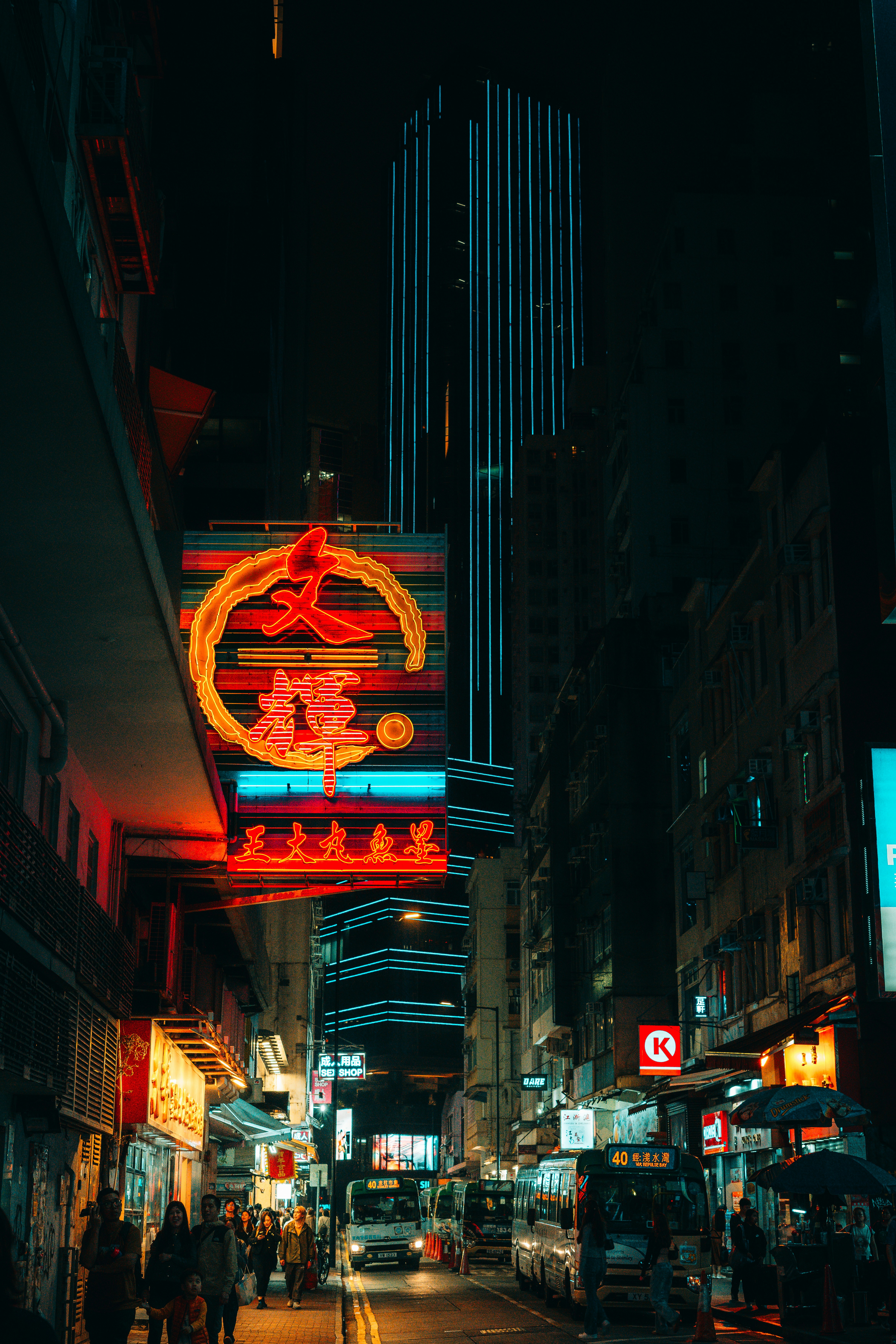 Hong Kong Street View - Sun Hung | Neon signs illuminate a busy city street at night.