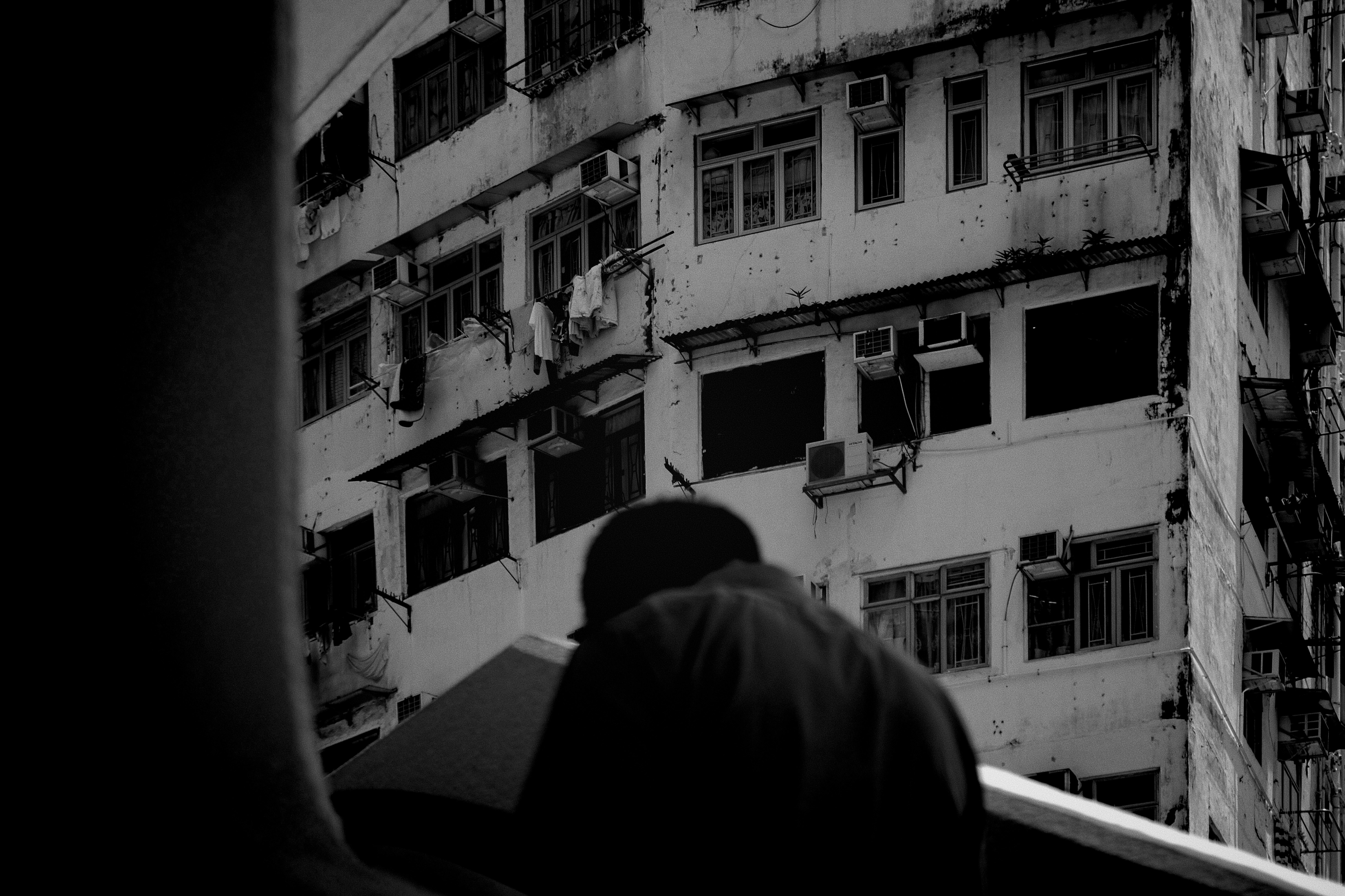Person looking at a weathered apartment building