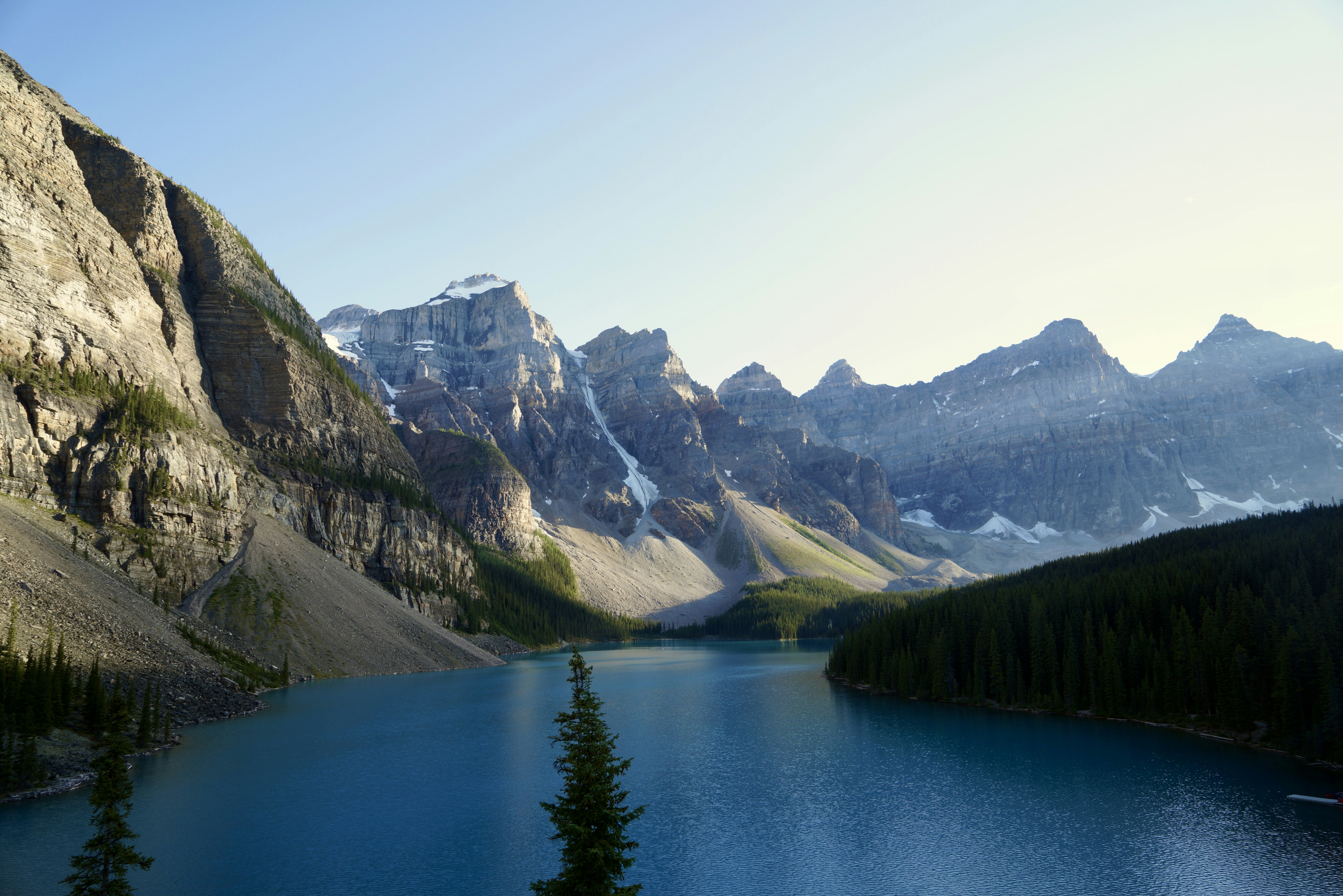 Turquoise lake surrounded by rocky mountains and pine trees