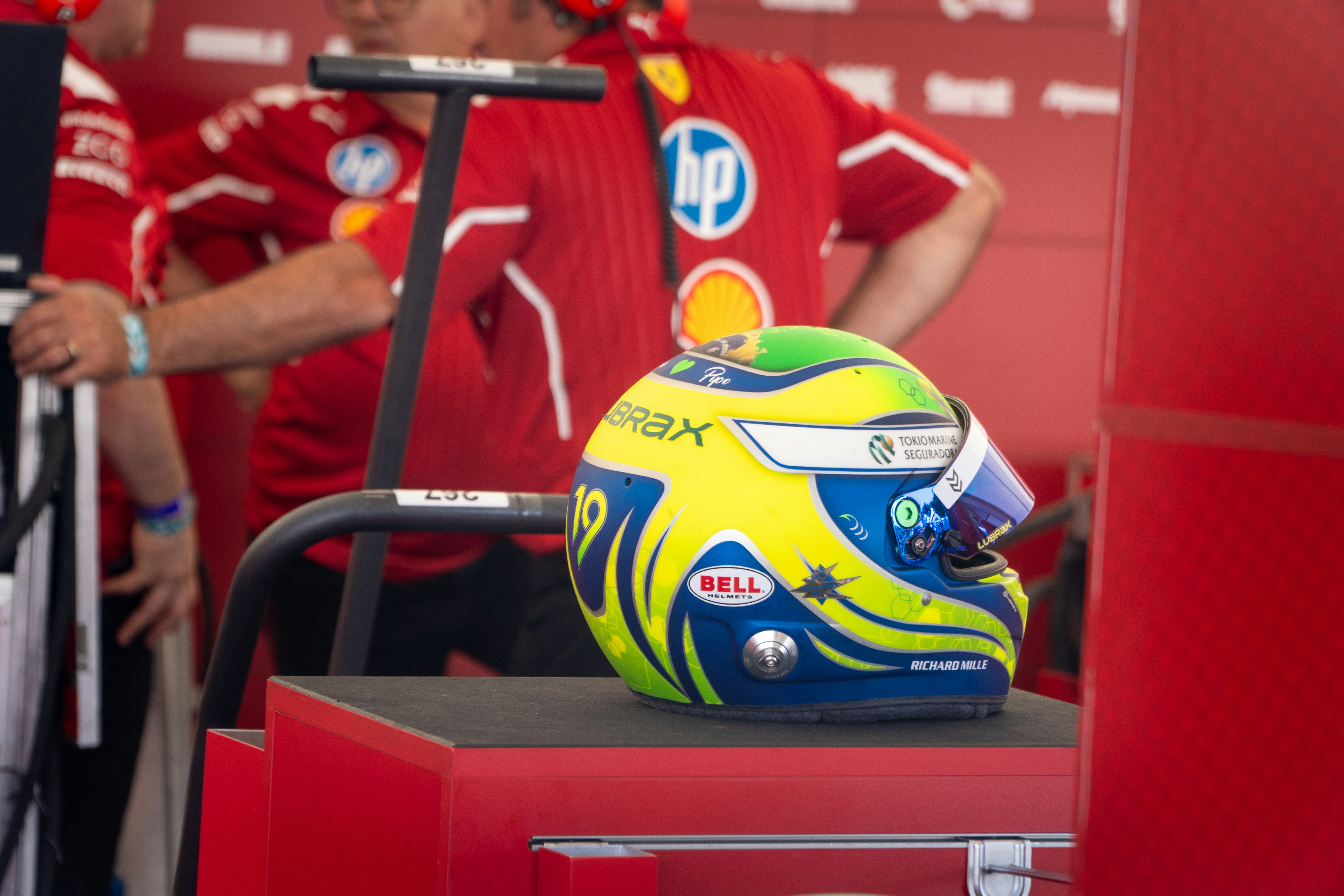 Formula 1 helmet with blue, yellow, and green design.
