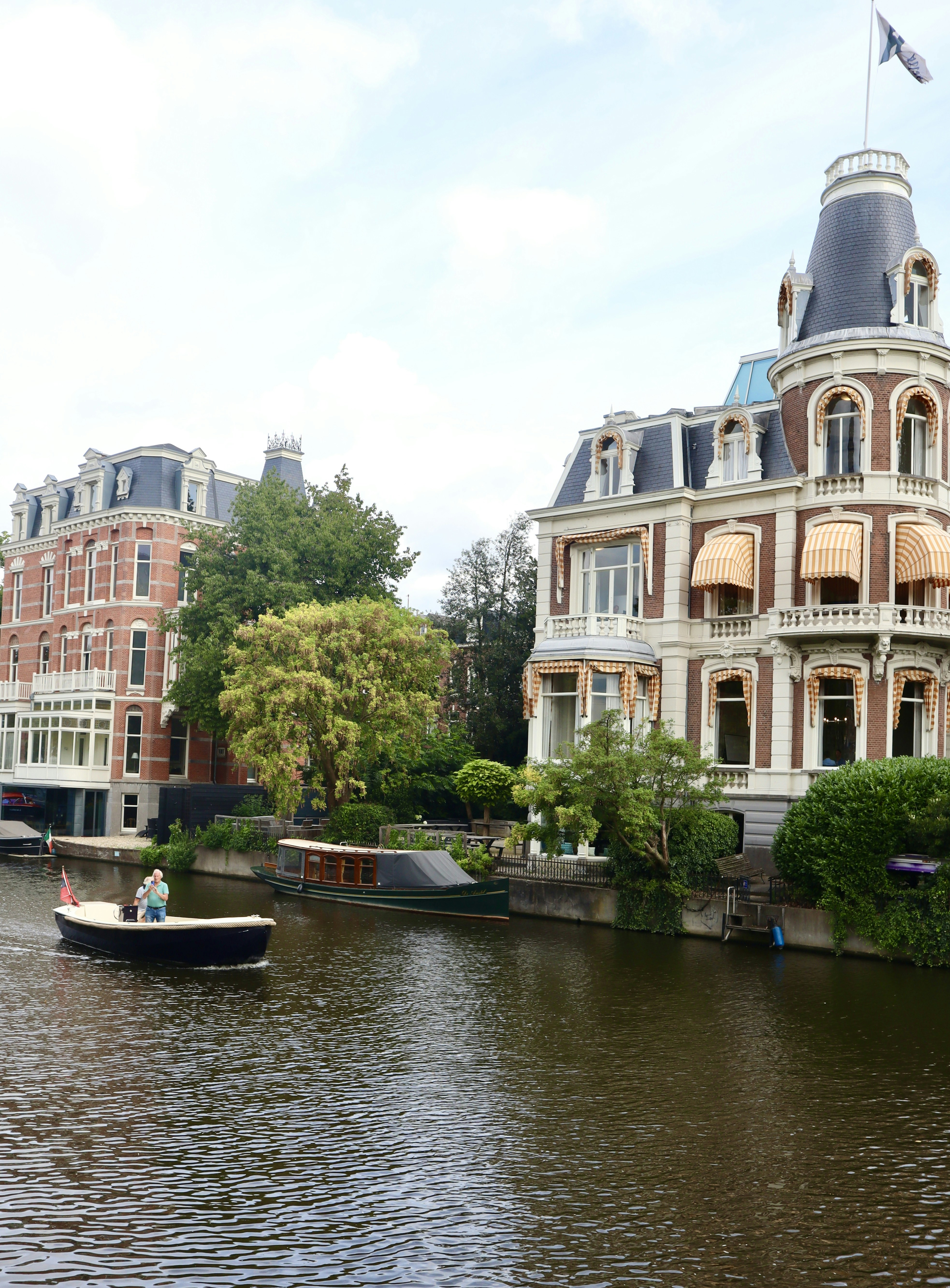 Canal Cruise in Amsterdam, The Netherlands | Boat on canal passing ornate buildings in amsterdam
