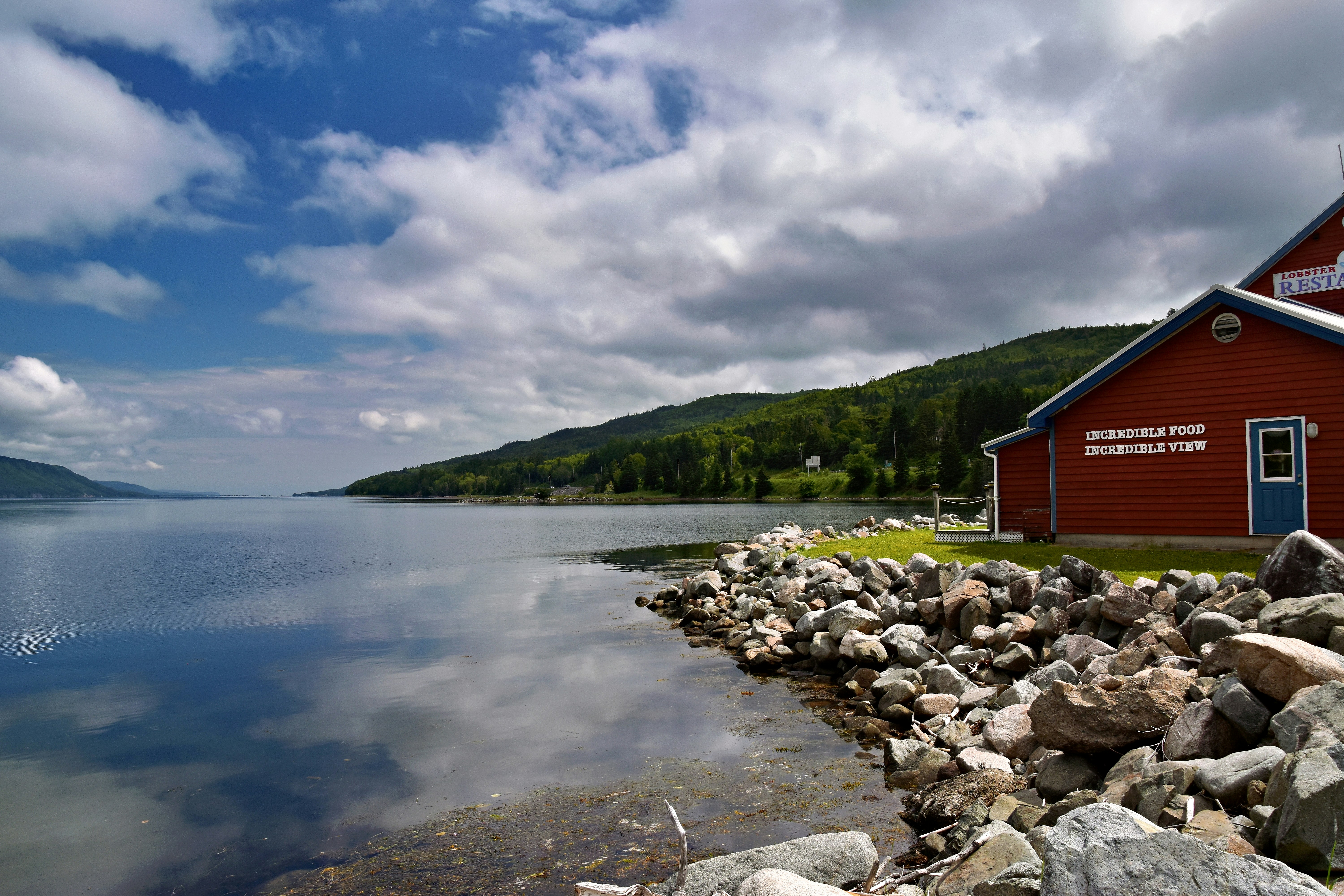 Red building by a calm lake with mountains