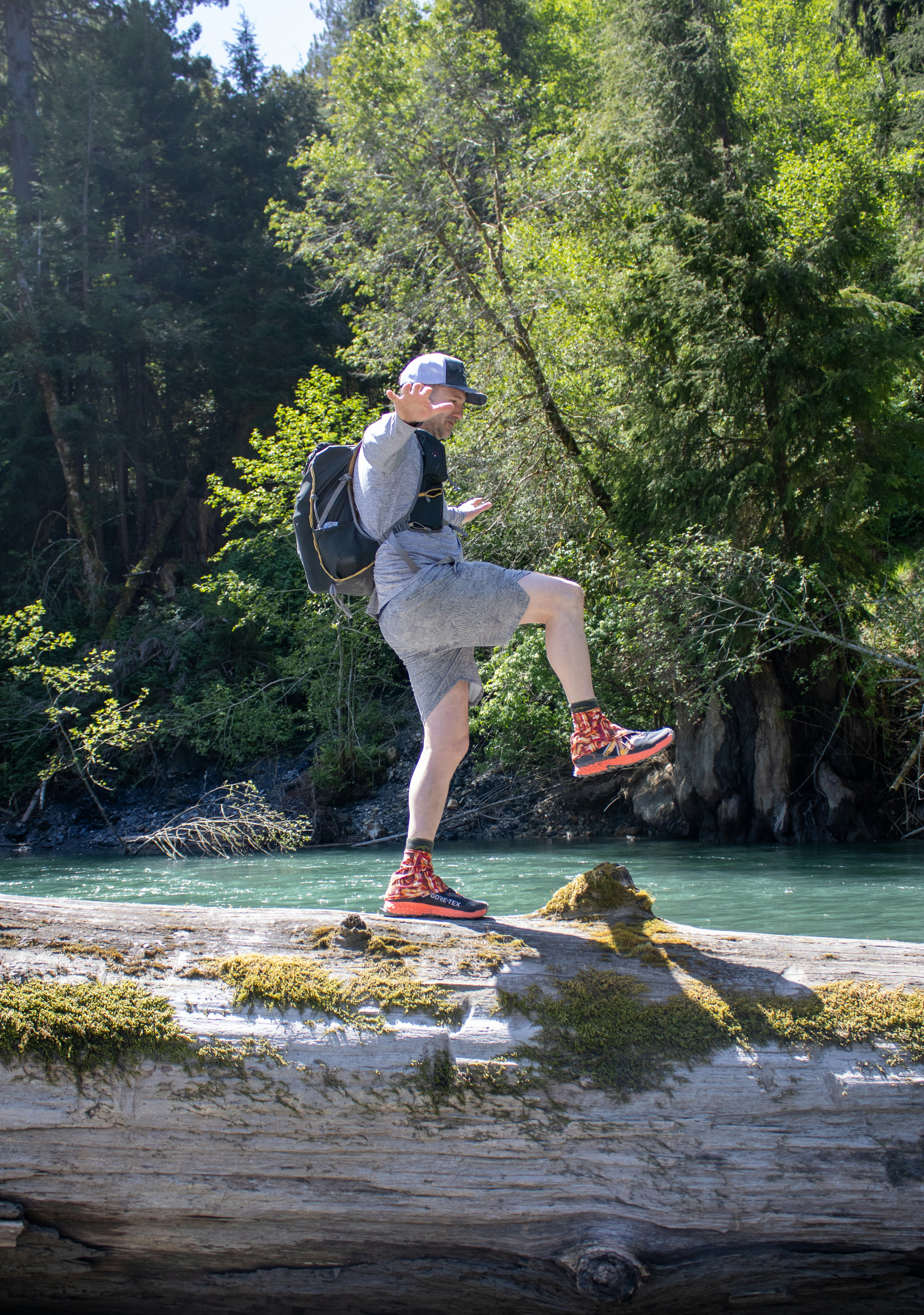 Hiker's Leap: Balancing on a Moss-Covered Log Over a Turquoise River