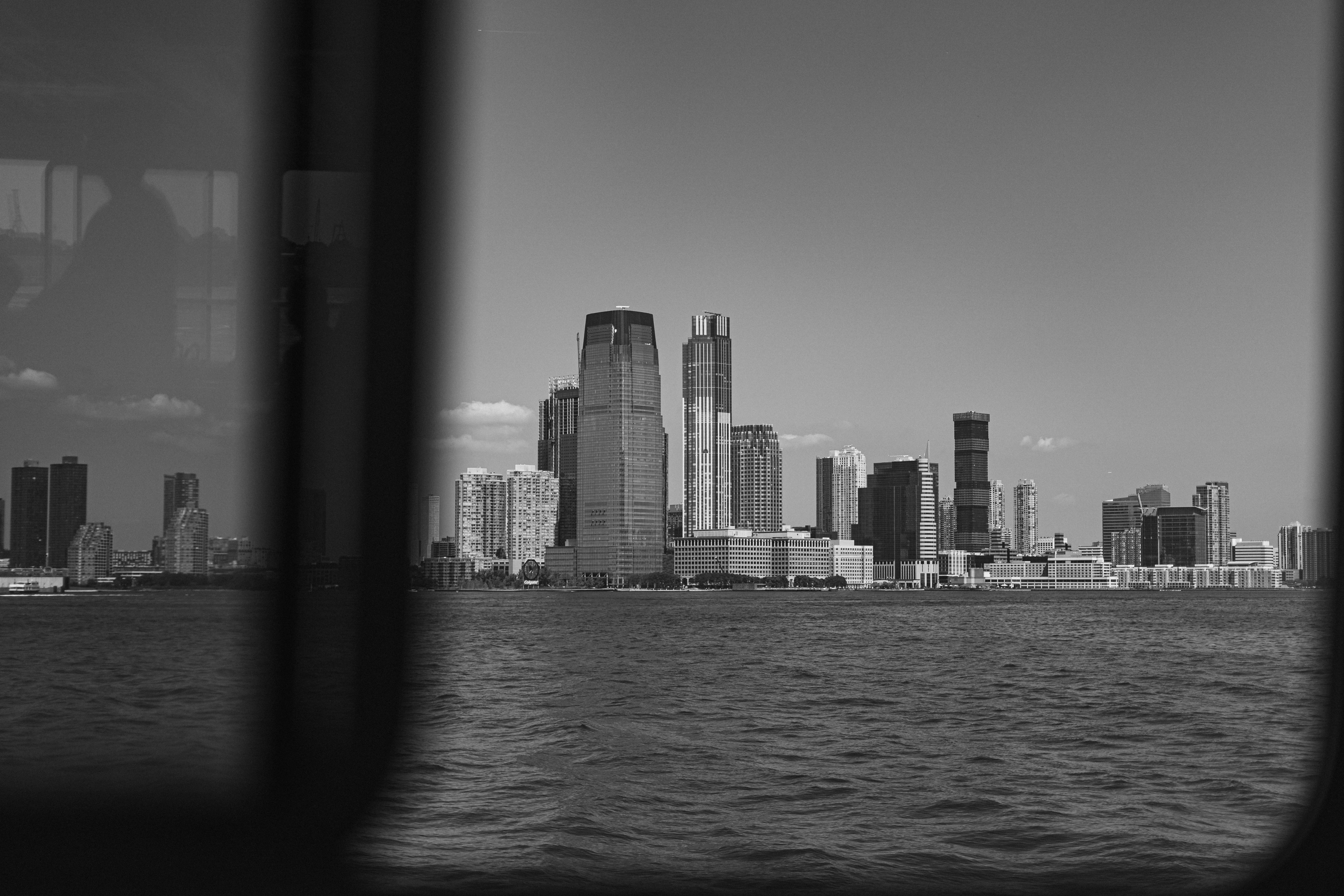 New York City scape from Statue of Liberty Ferry boat. | City skyline viewed across the water