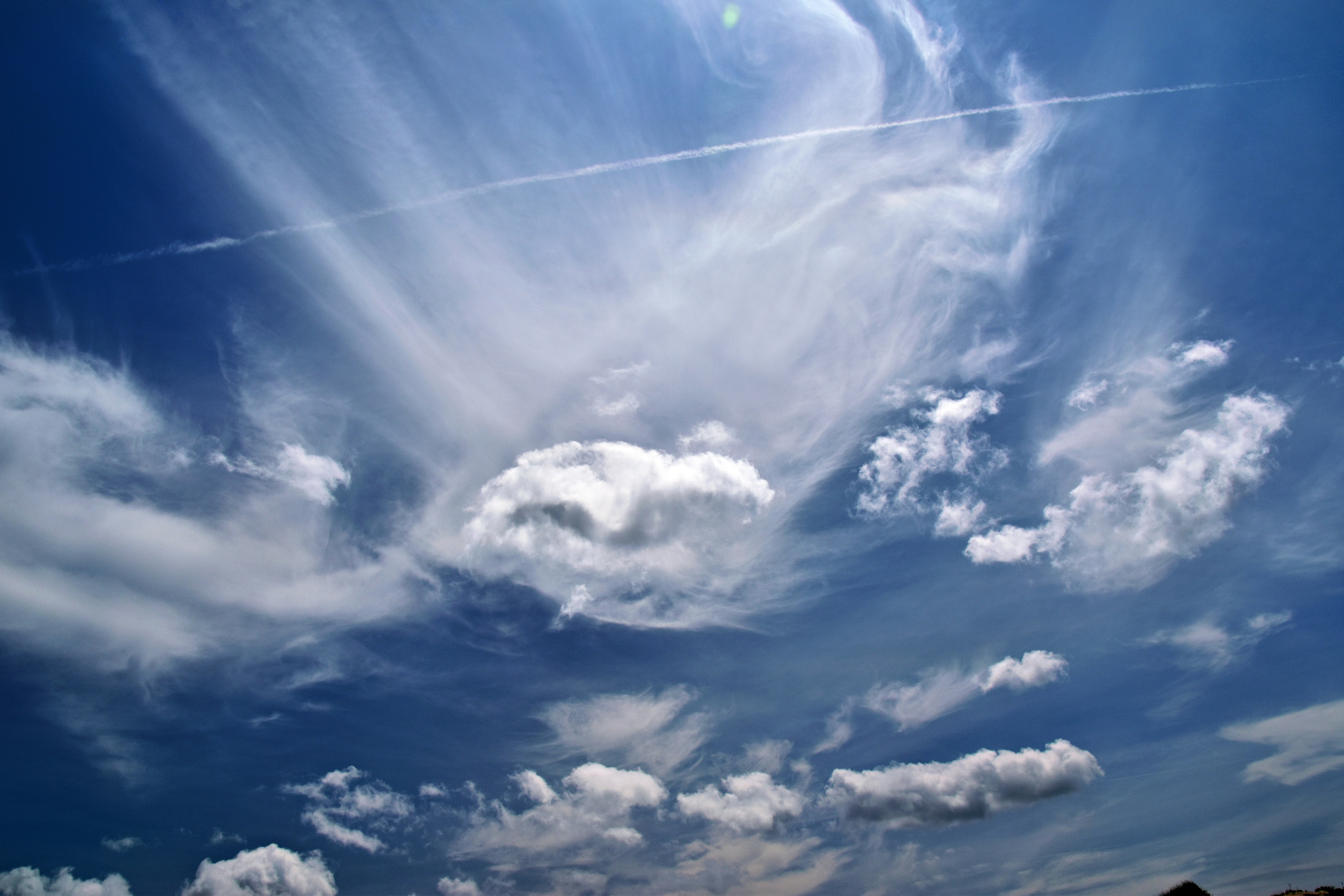 Wispy clouds drift across a bright blue sky.