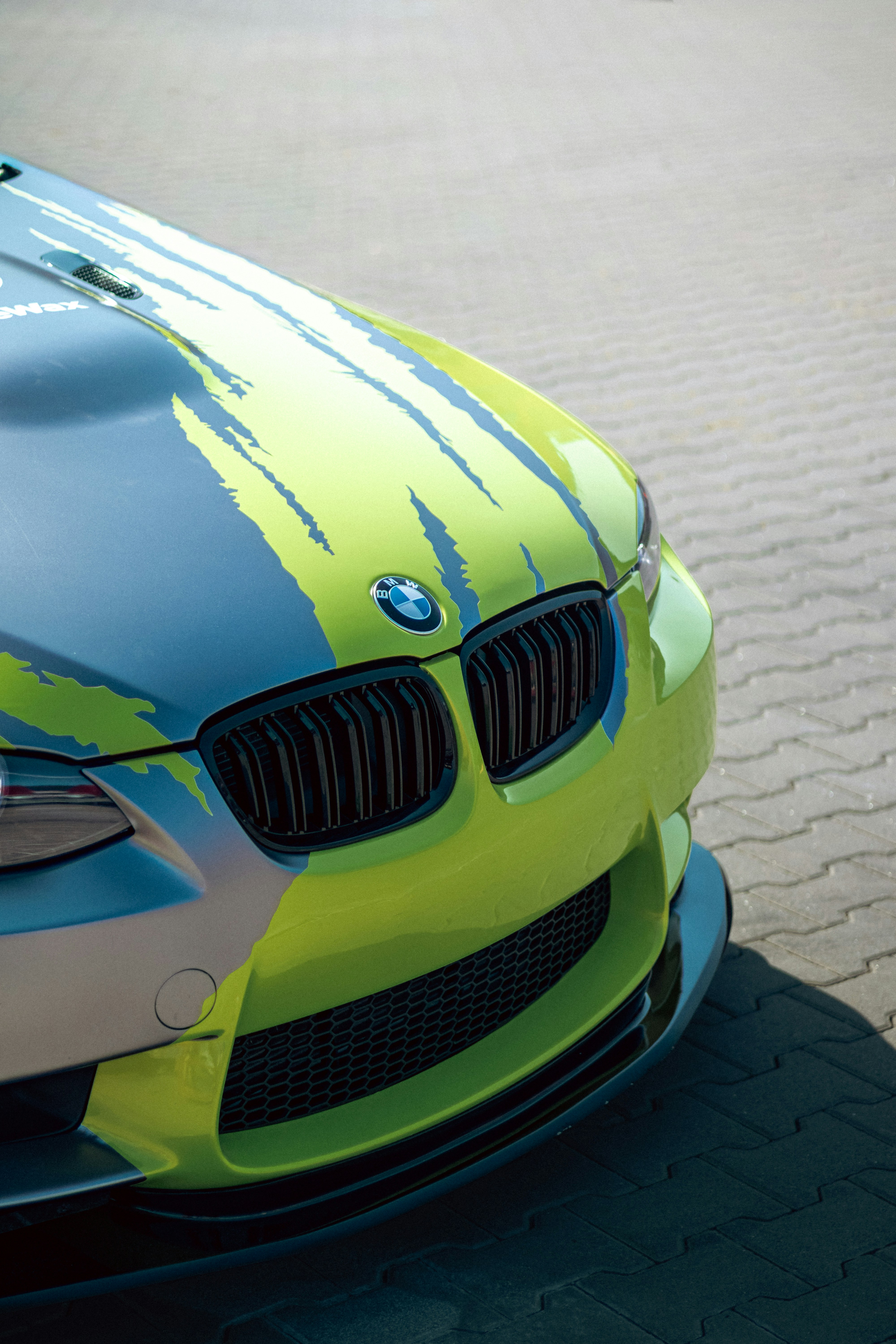Close-up of a BMW car with a yellow racing stripe.