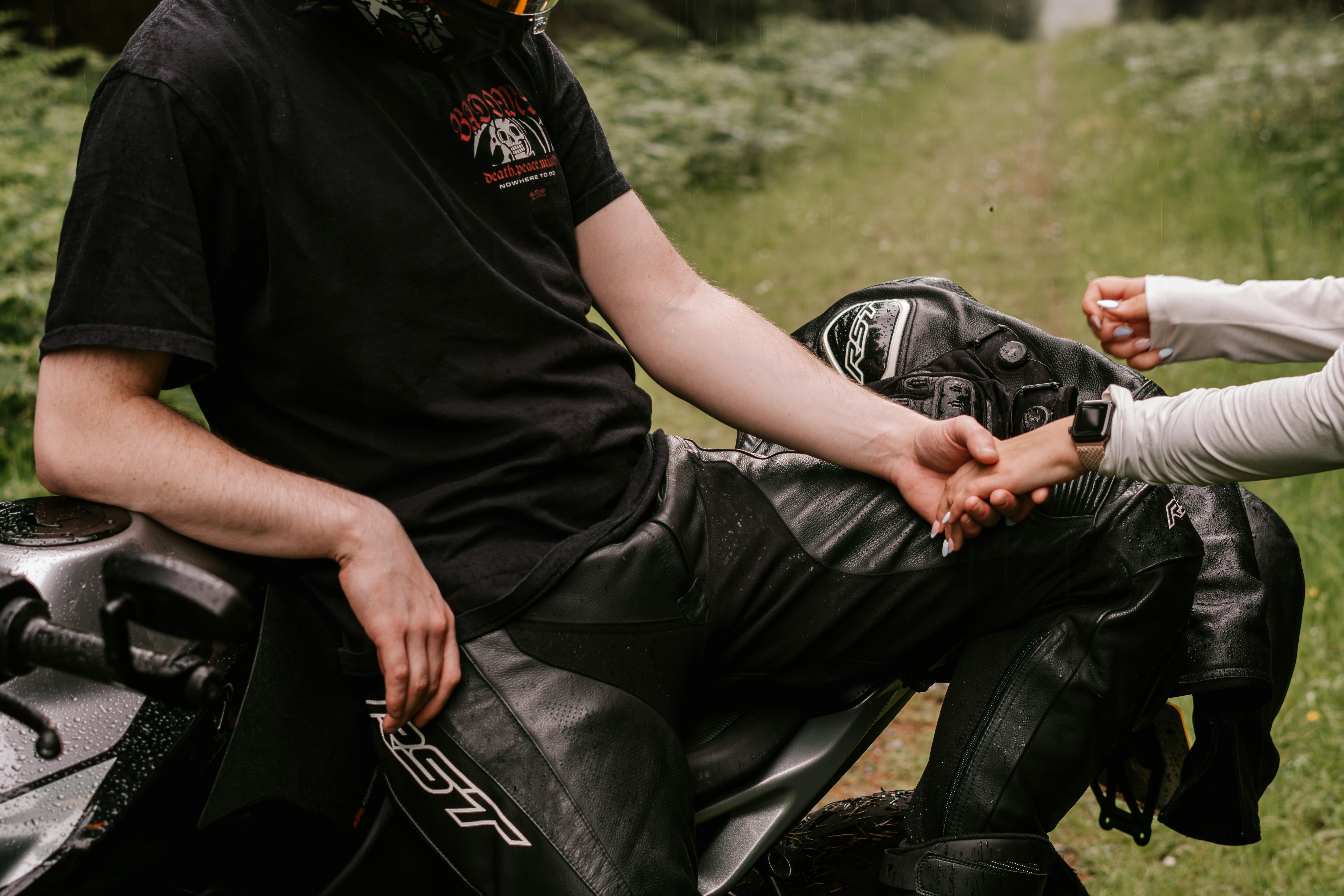 Couple holding hands by a motorcycle