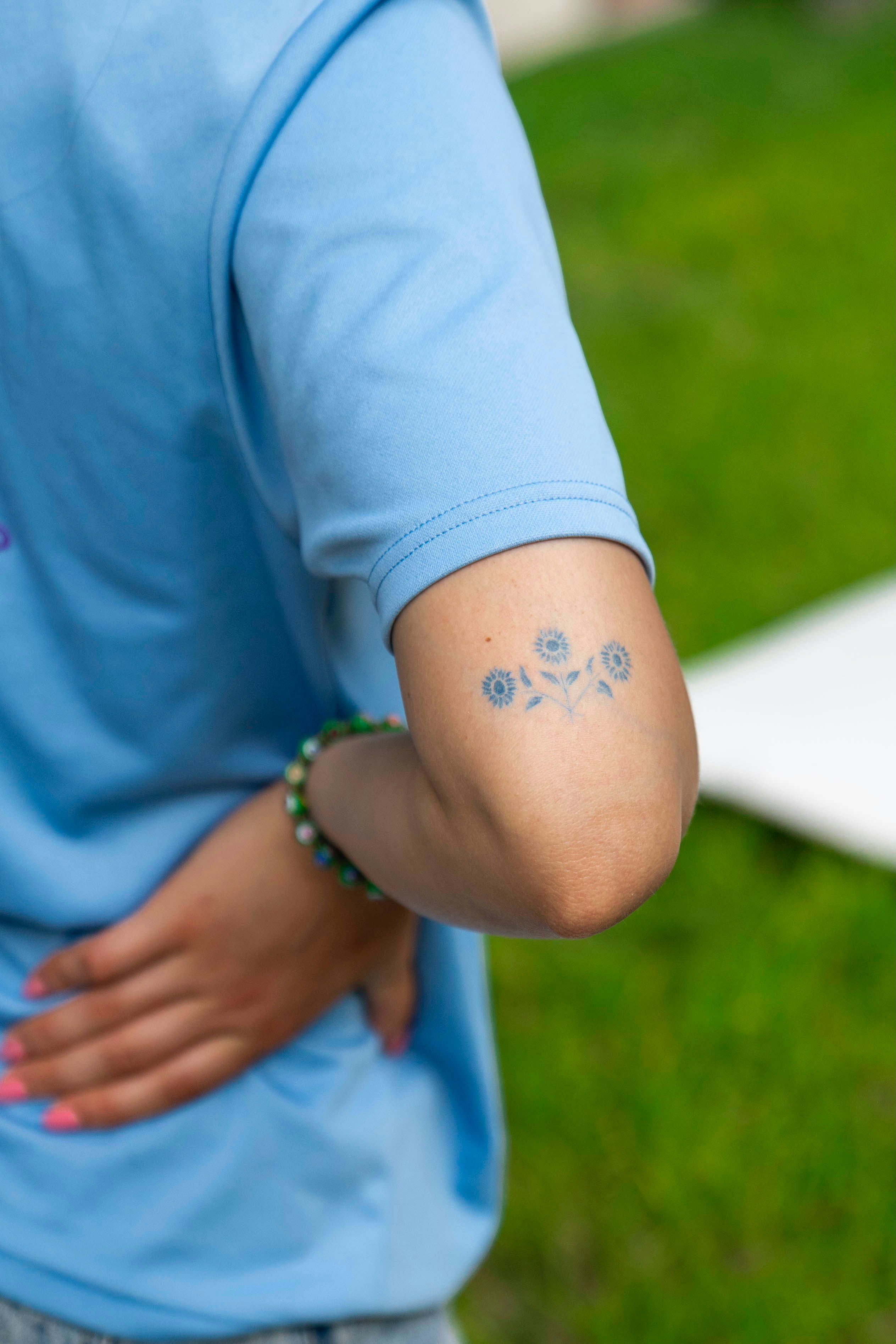 Woman's arm with a small floral tattoo