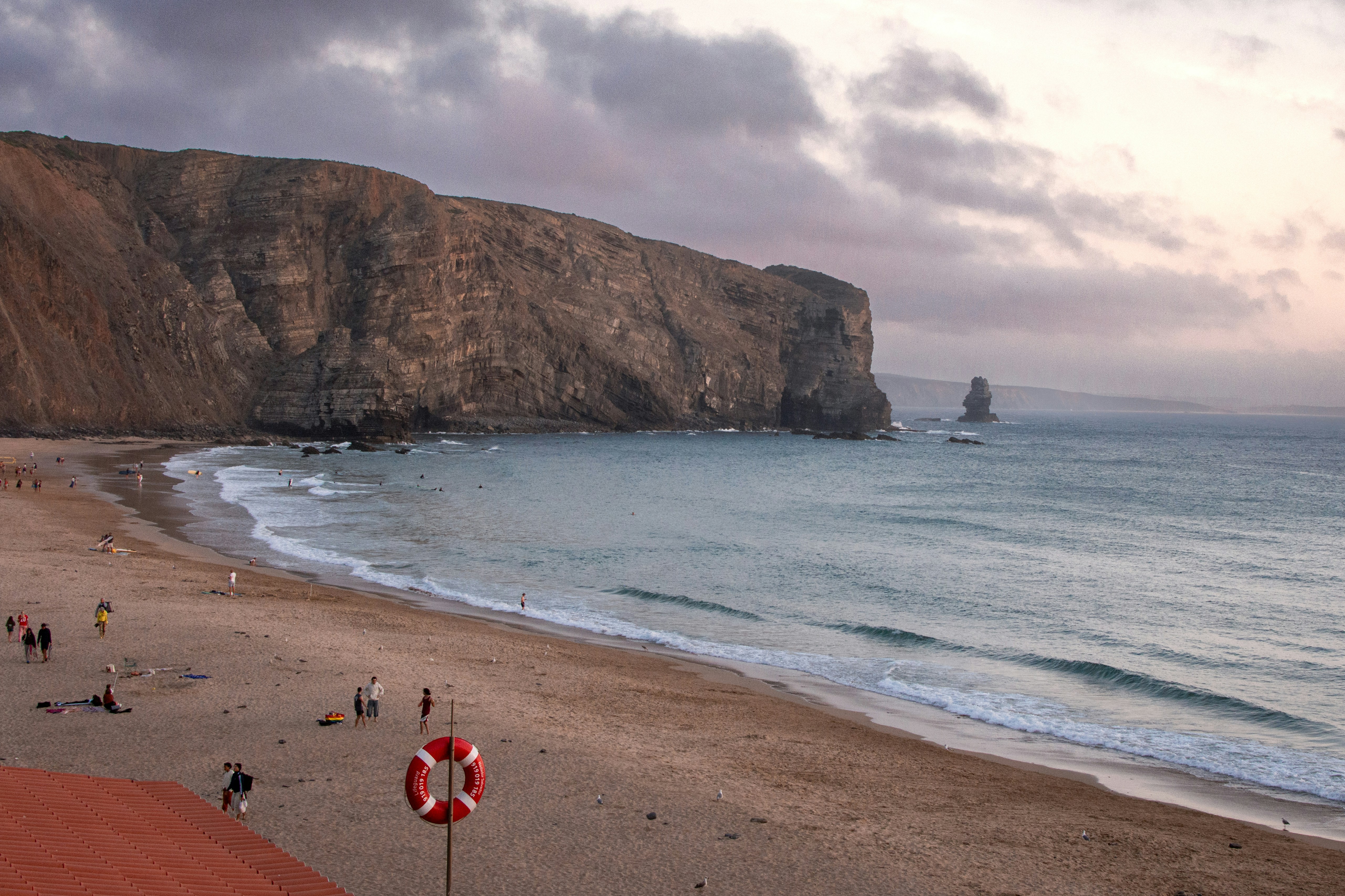 Beach with cliffs and ocean waves at sunset