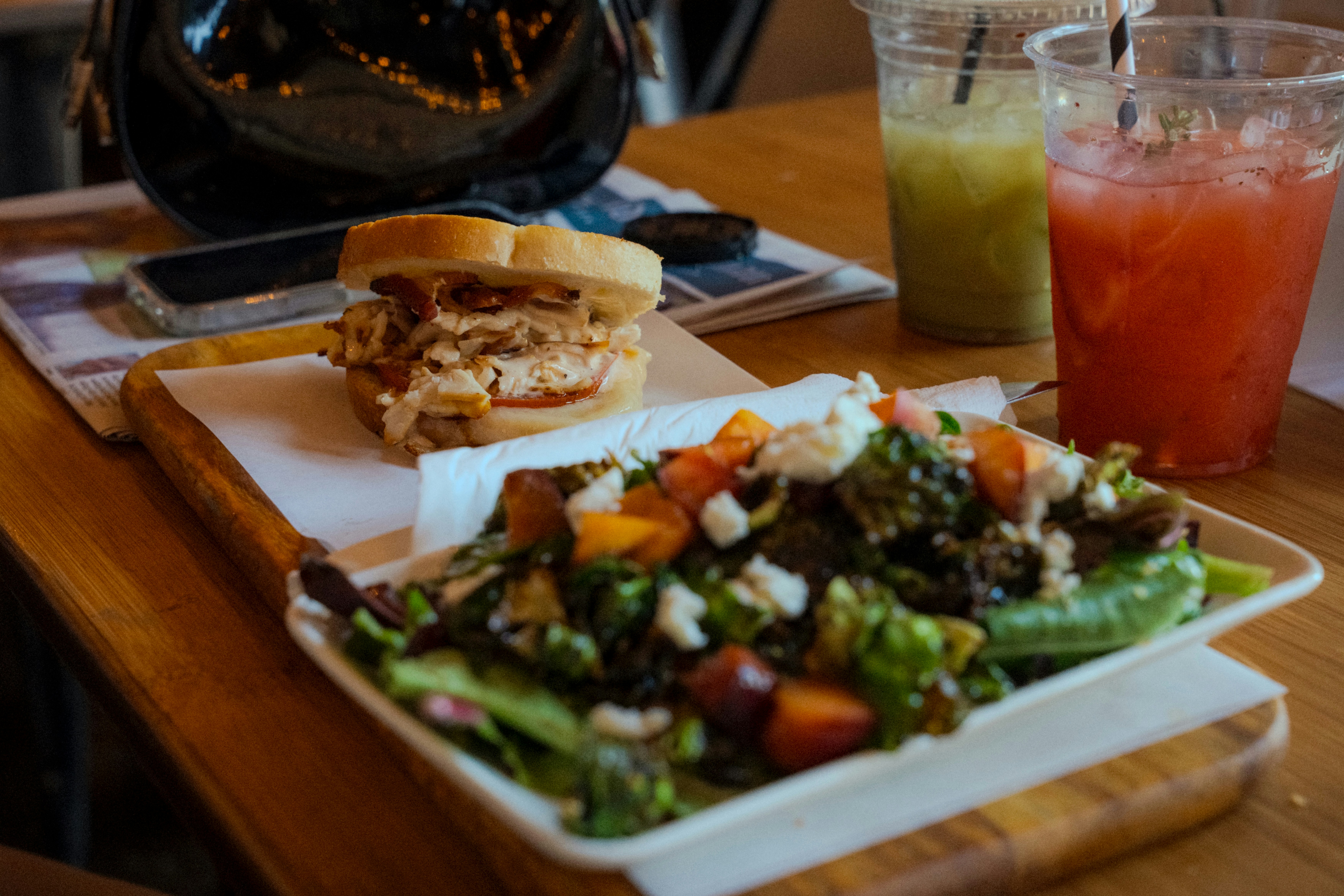Bright Greens in the Foreground: A Fresh Salad Portrait with a Sandwich Backdrop