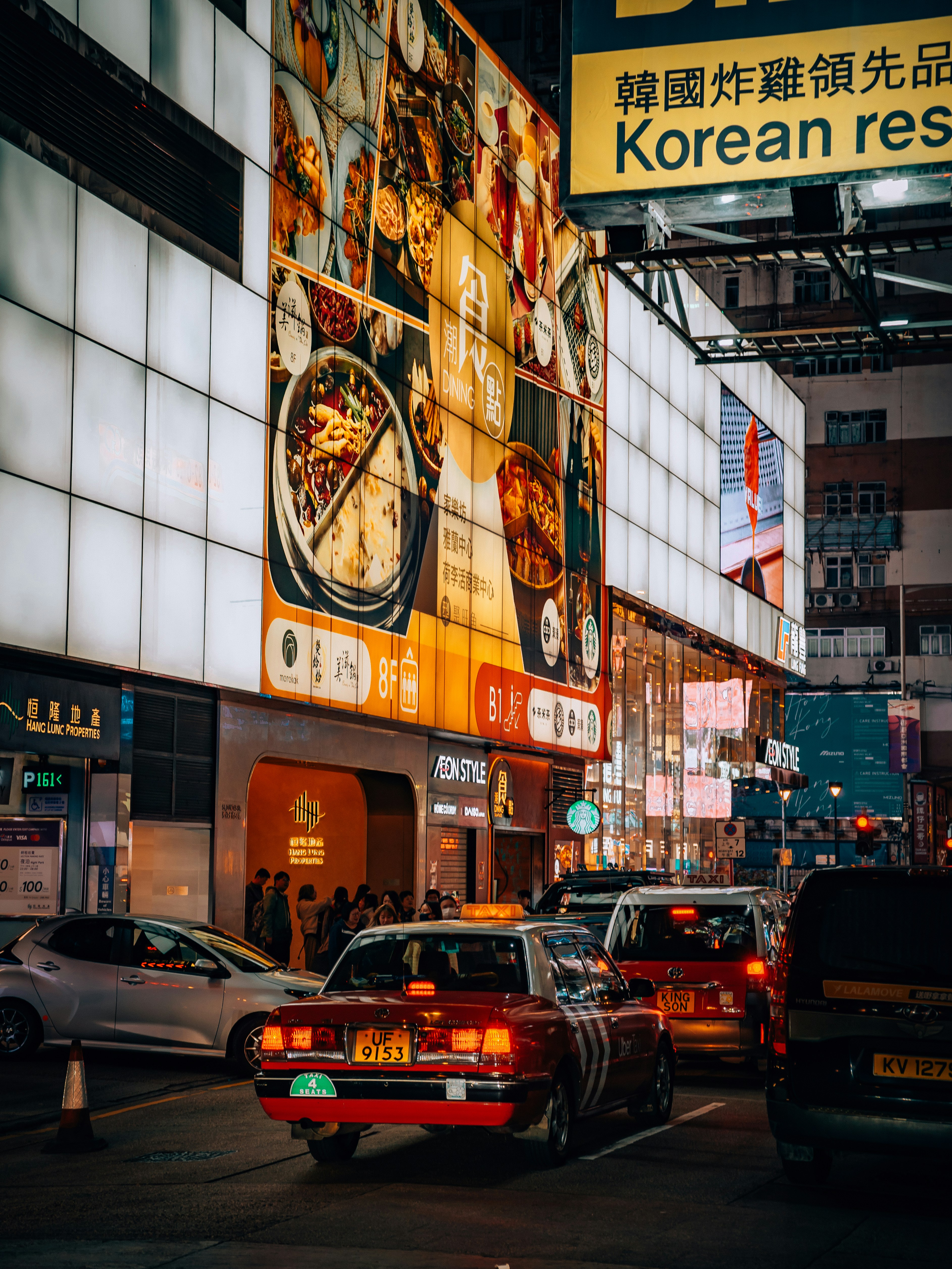 Busy city street at night with korean restaurant sign
