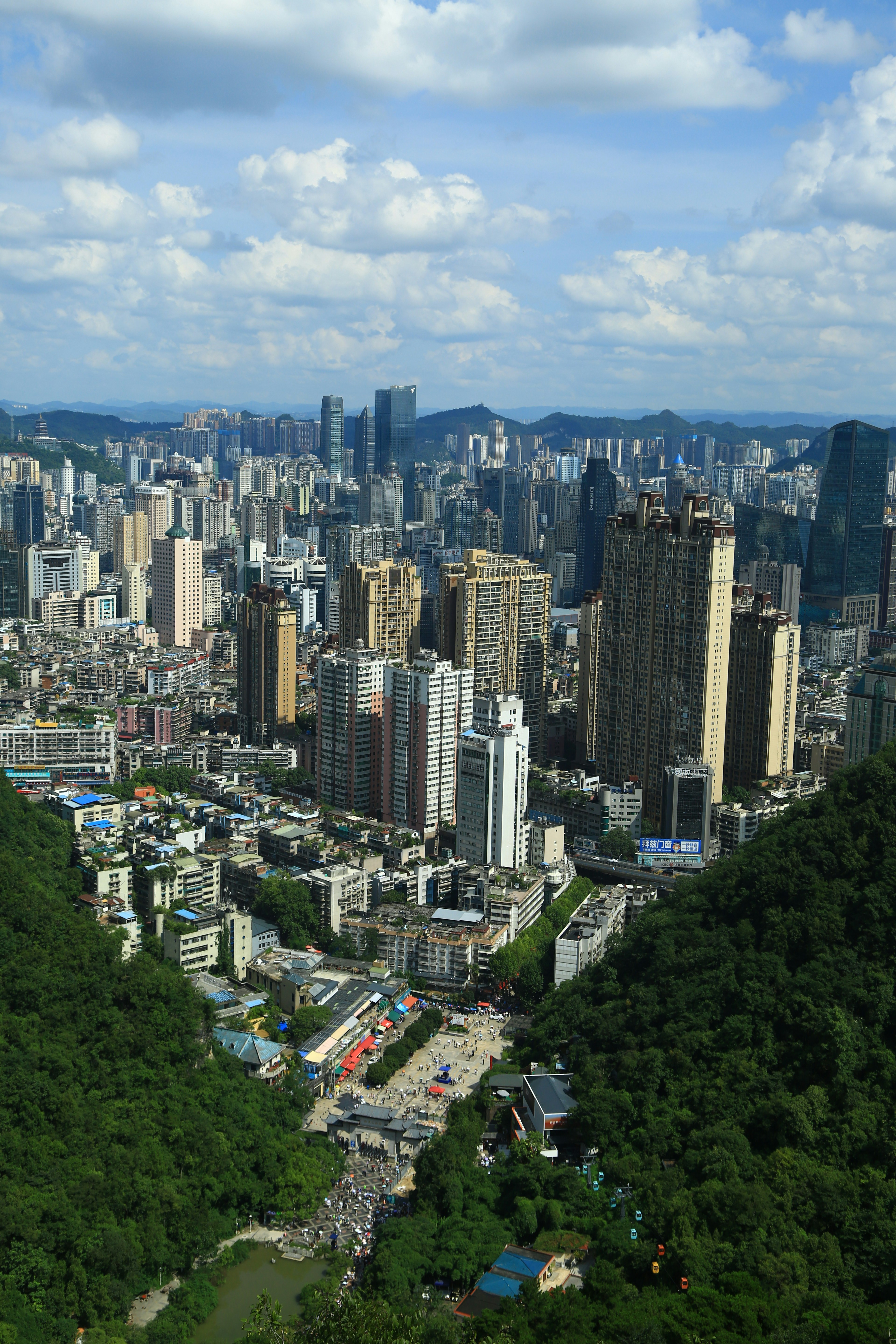 A sprawling cityscape nestled among lush green hills.