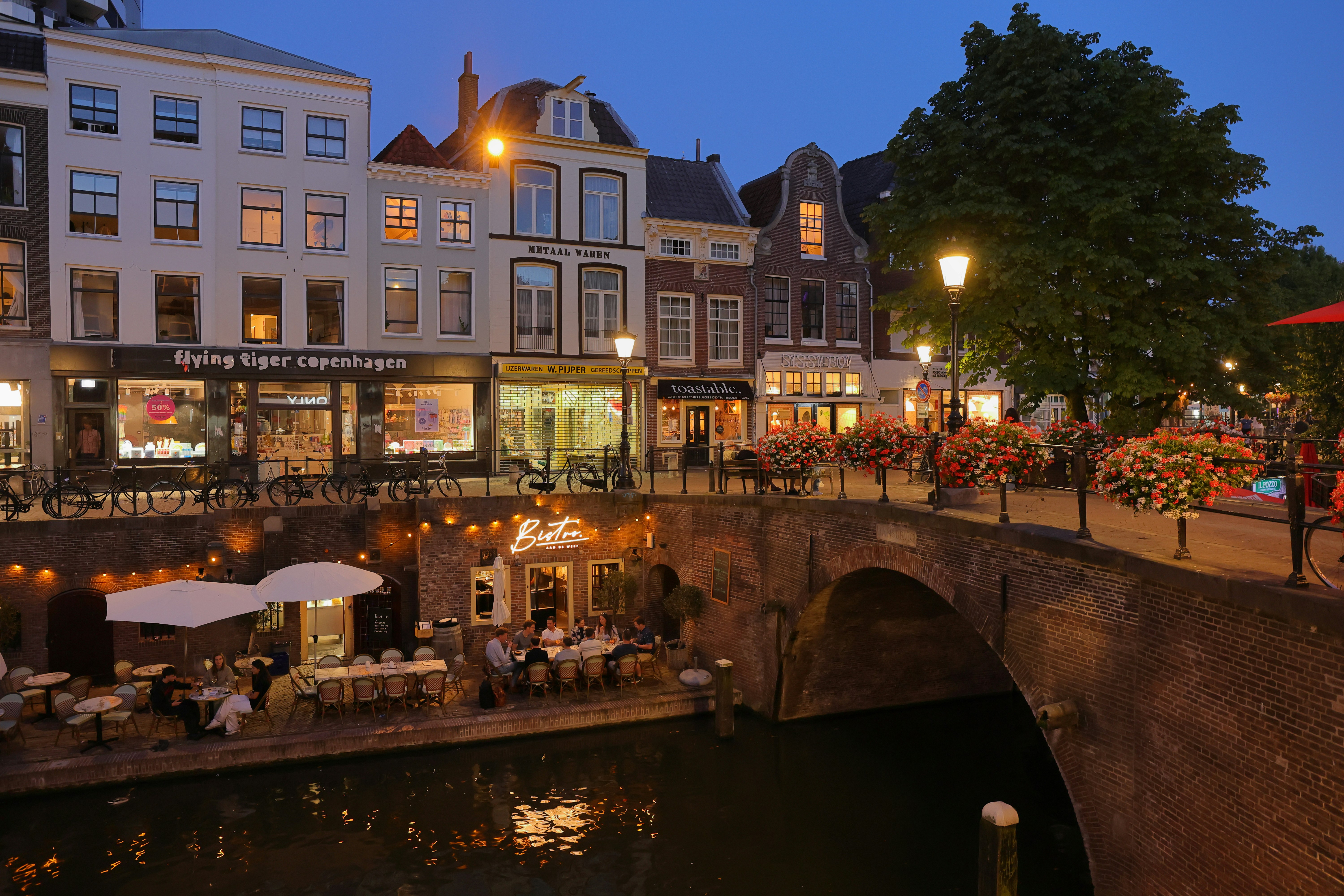City canal with illuminated buildings and outdoor cafes