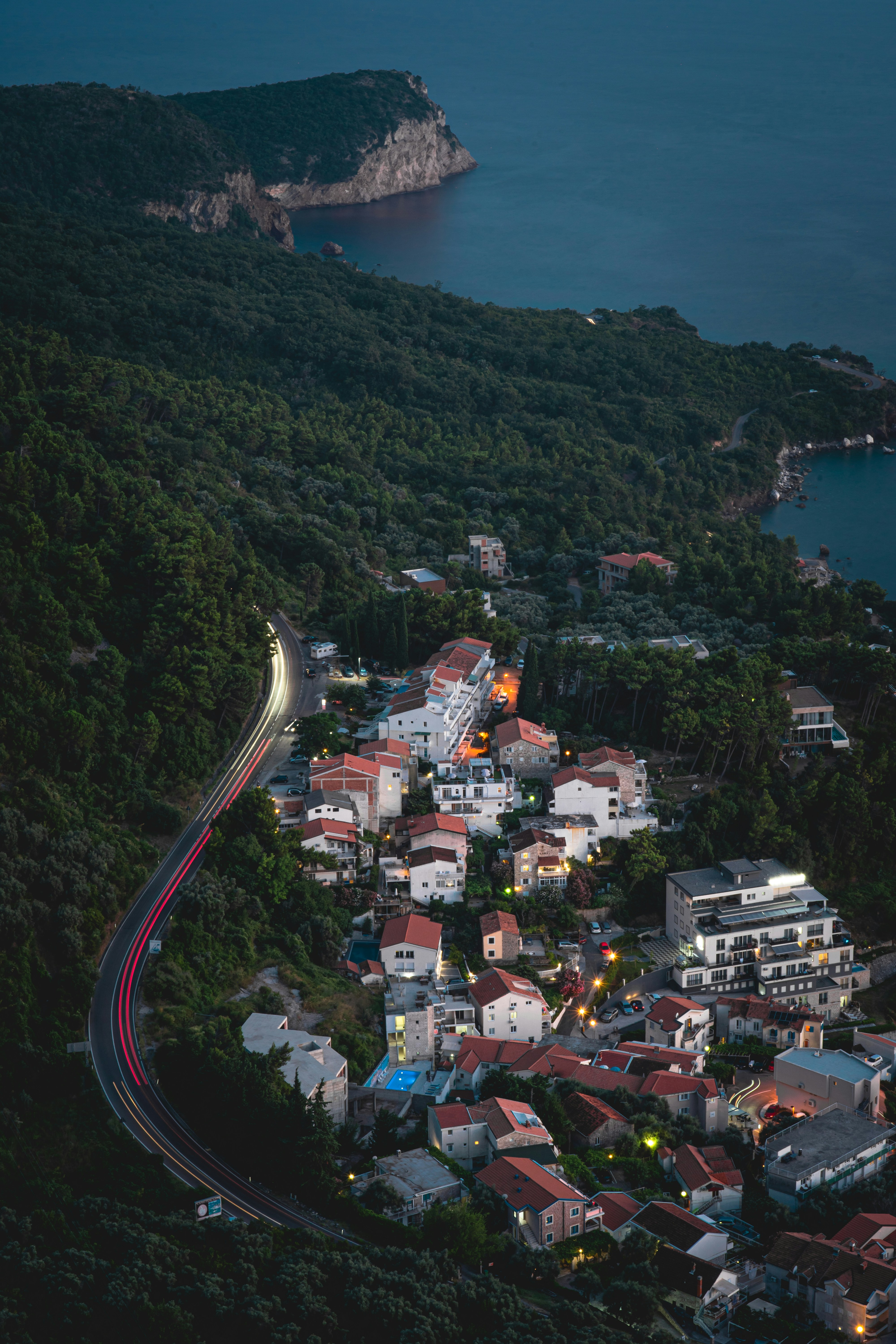 Coastal town nestled in green hills at dusk