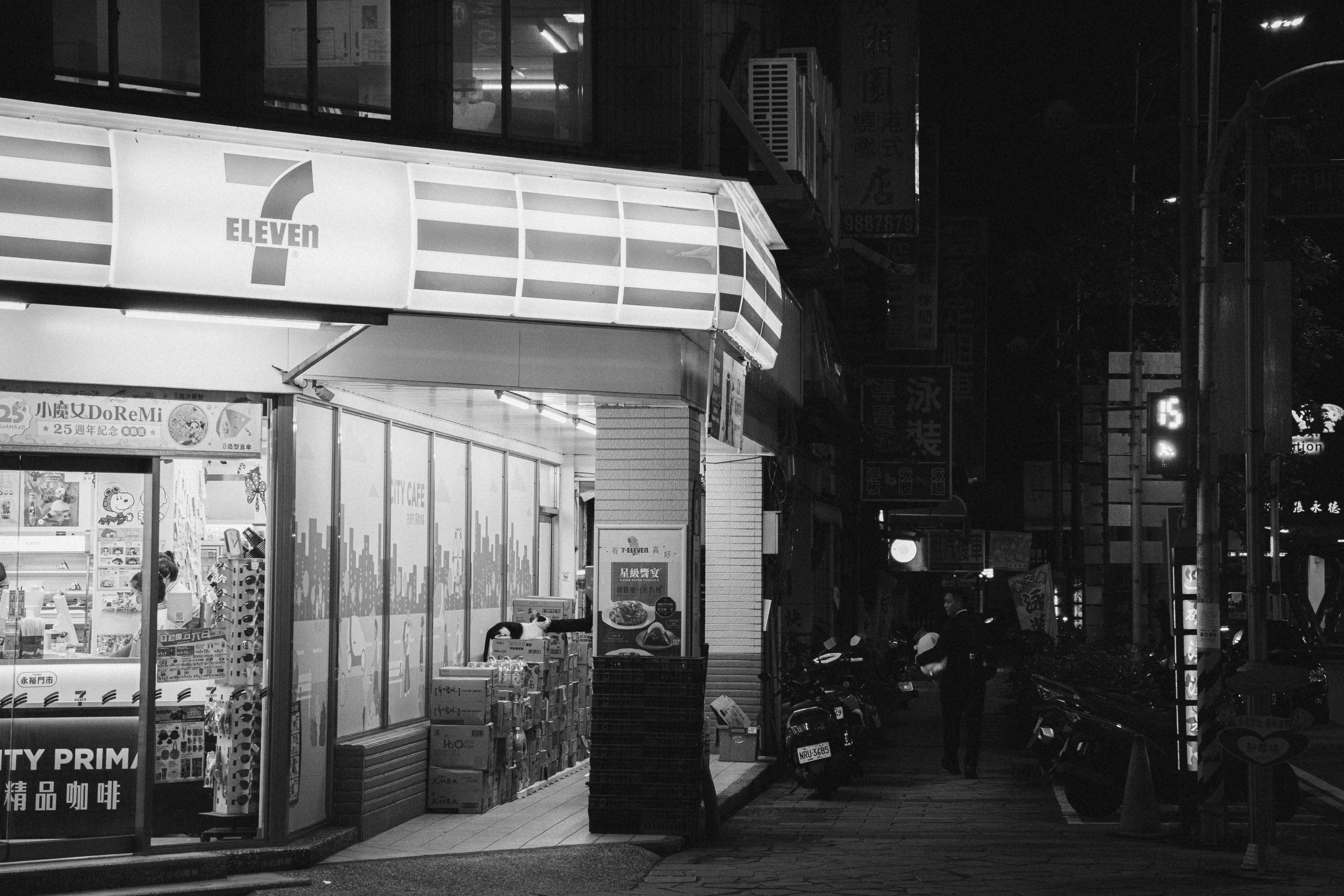 A 7-eleven store at night with parked motorcycles