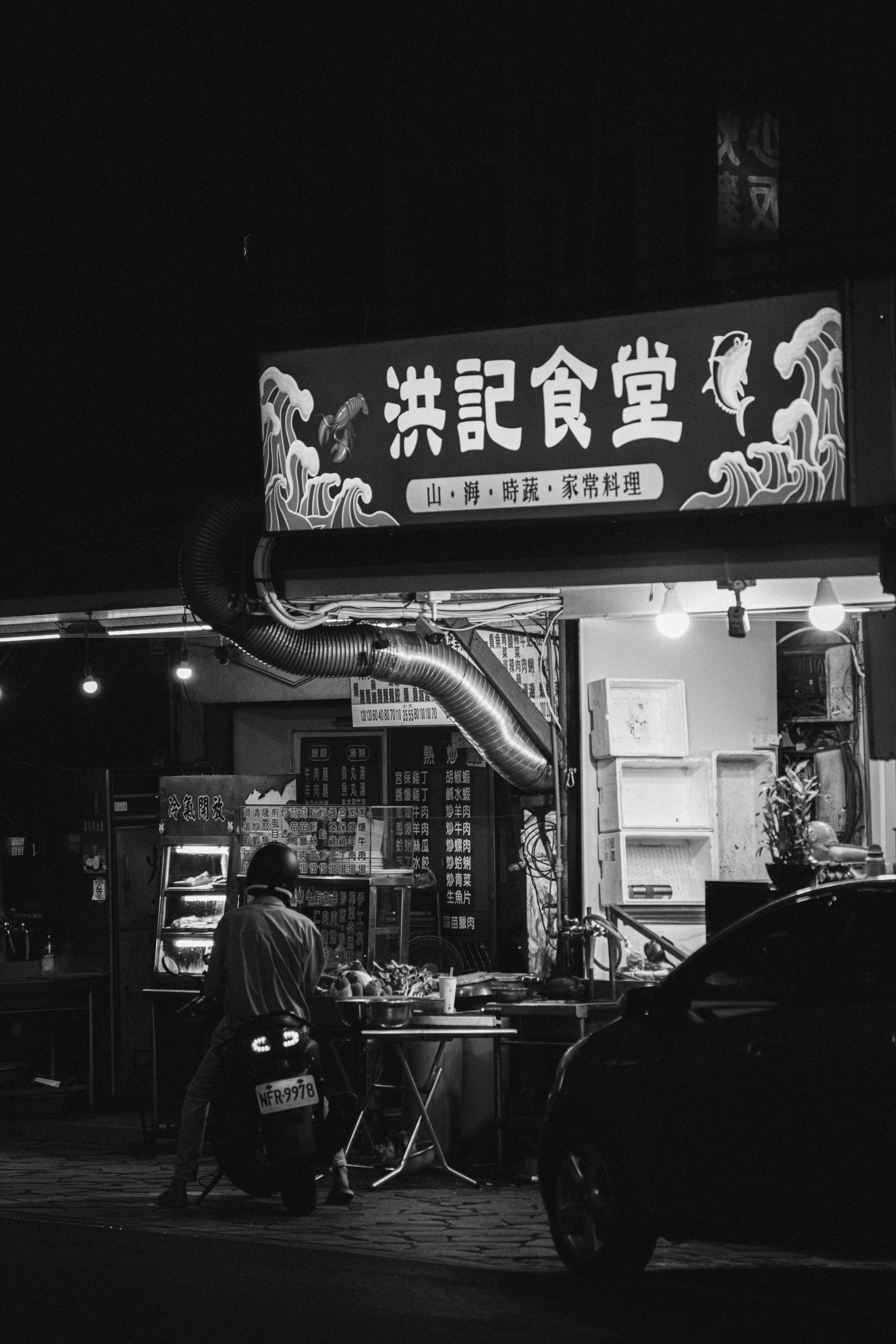 Person on a scooter at a night market stall.