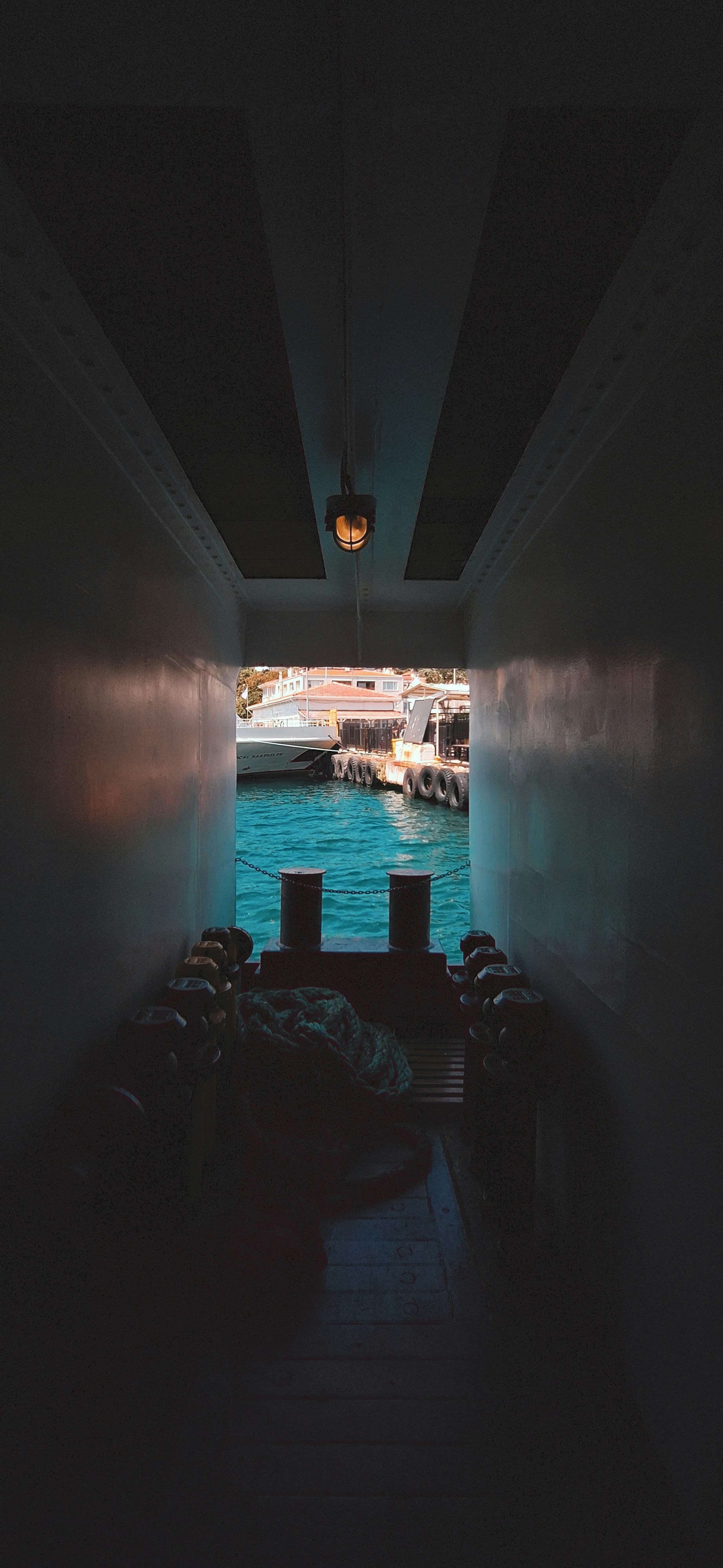 View of bright blue water from dark ferry corridor