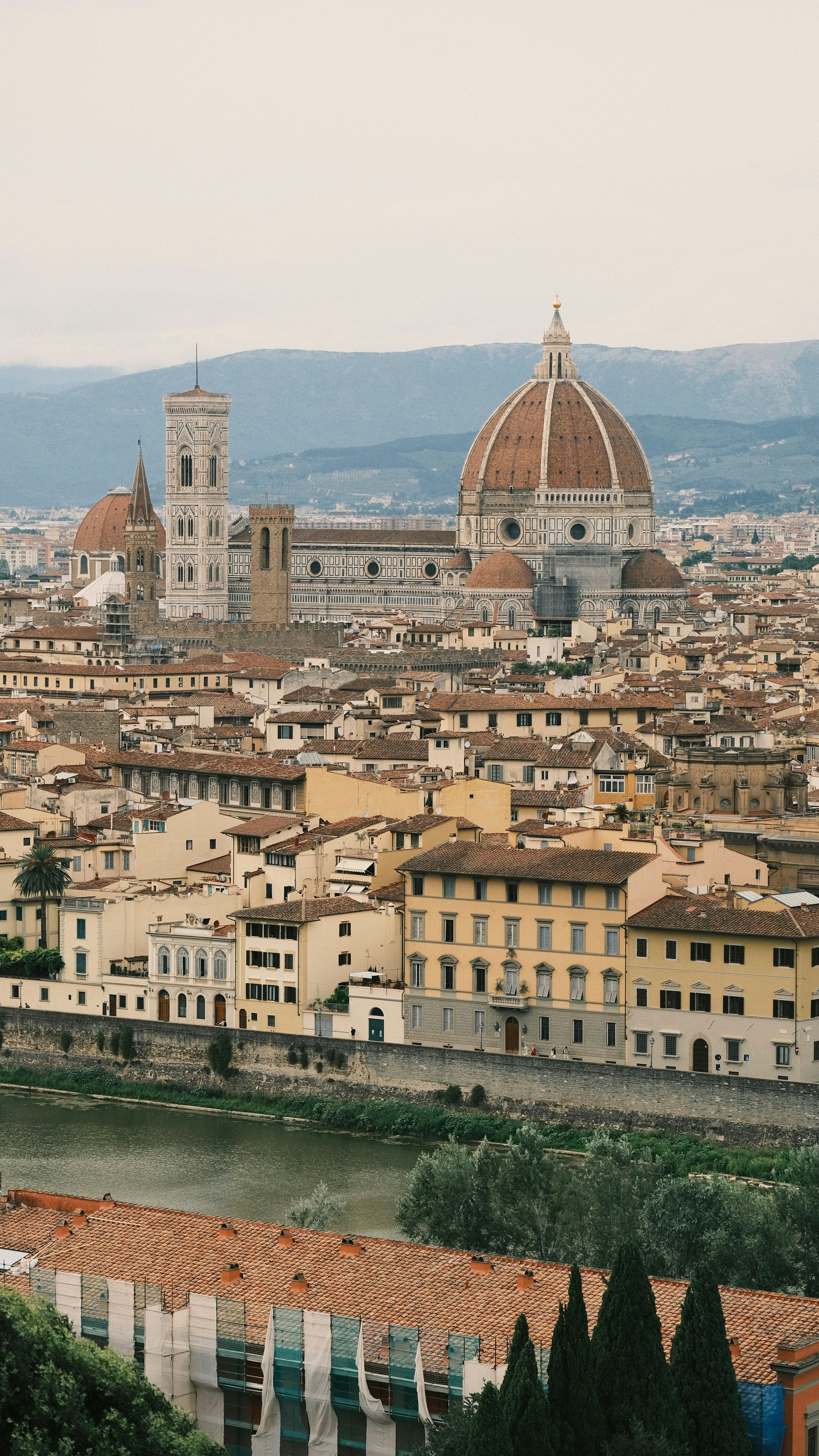 Panoramic view of Florence showcasing the iconic Duomo and surrounding historic buildings along the Arno River.