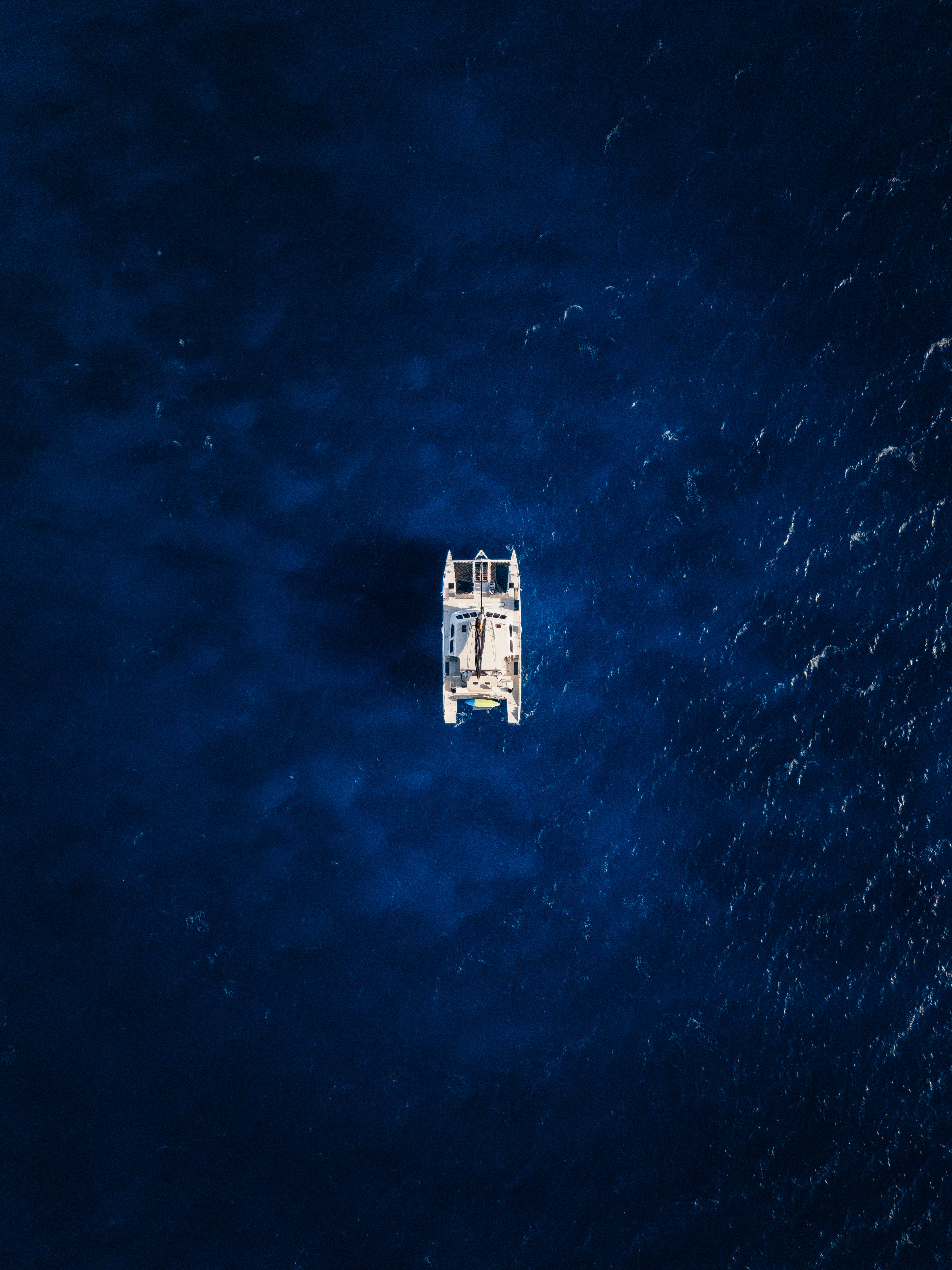 Lost at sea | White boat sailing on deep blue ocean