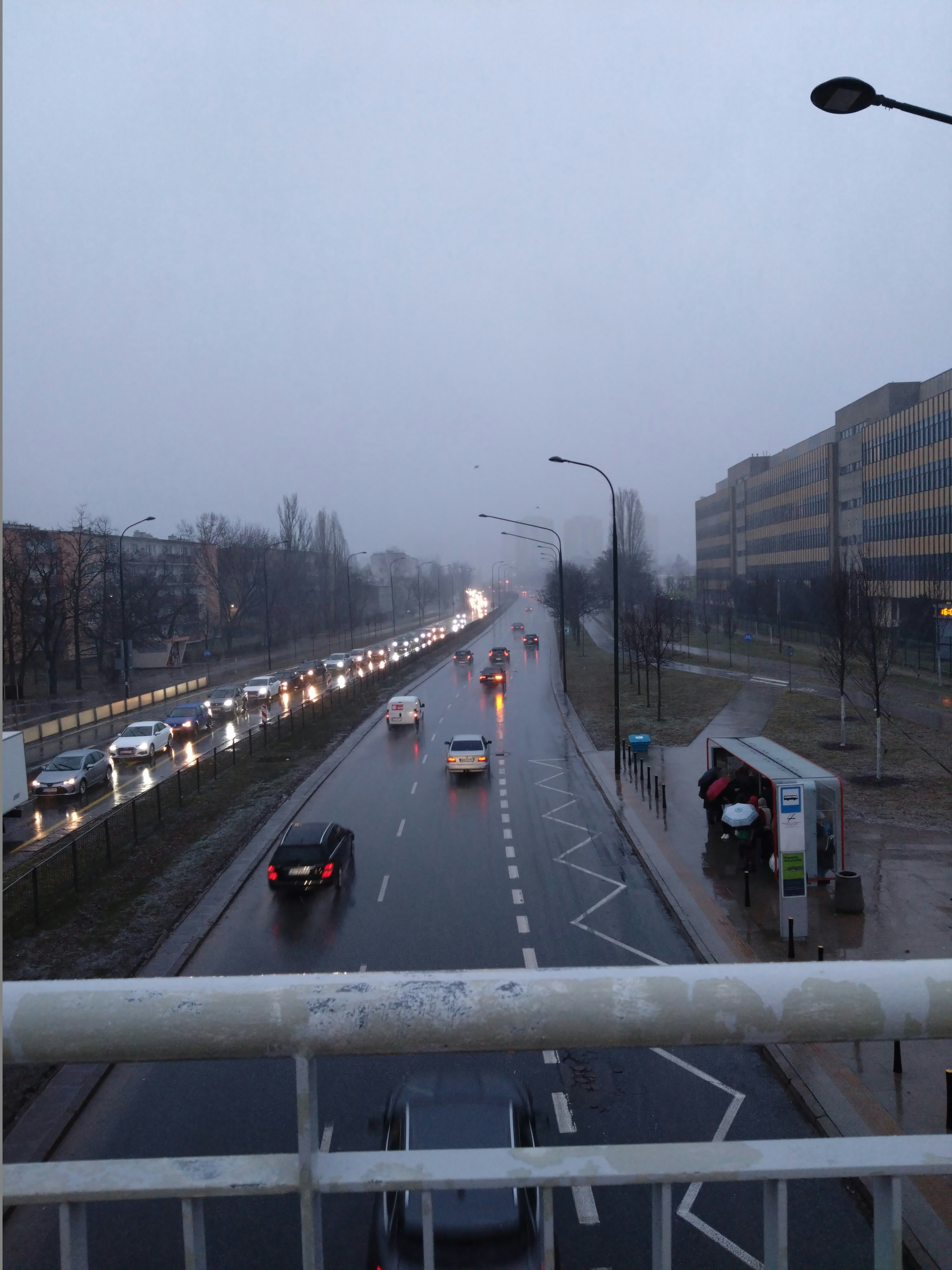 Cars driving on a wet road in the rain.