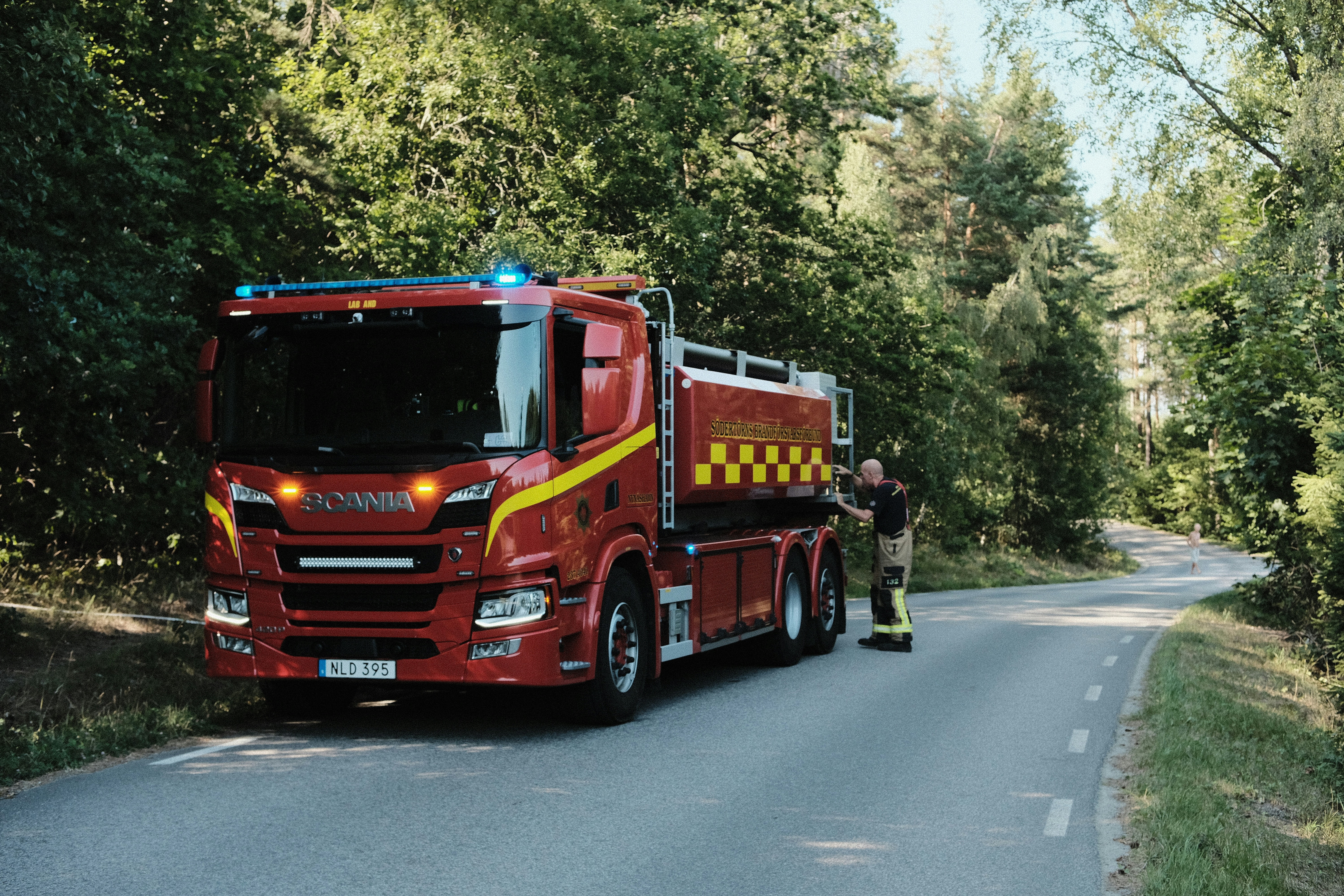 Firefighter near a red fire truck on a road