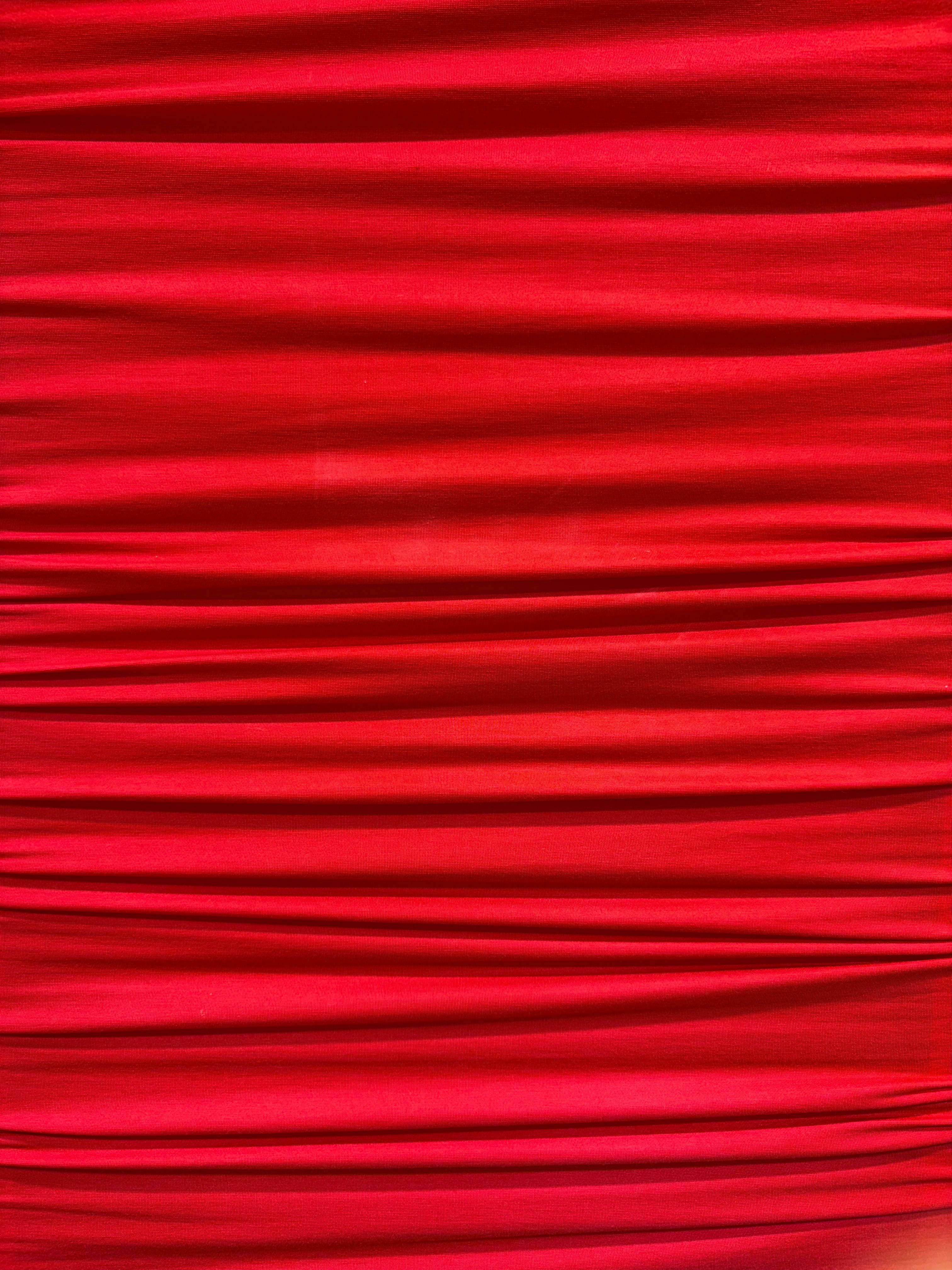 A close-up of red fabric with horizontal folds